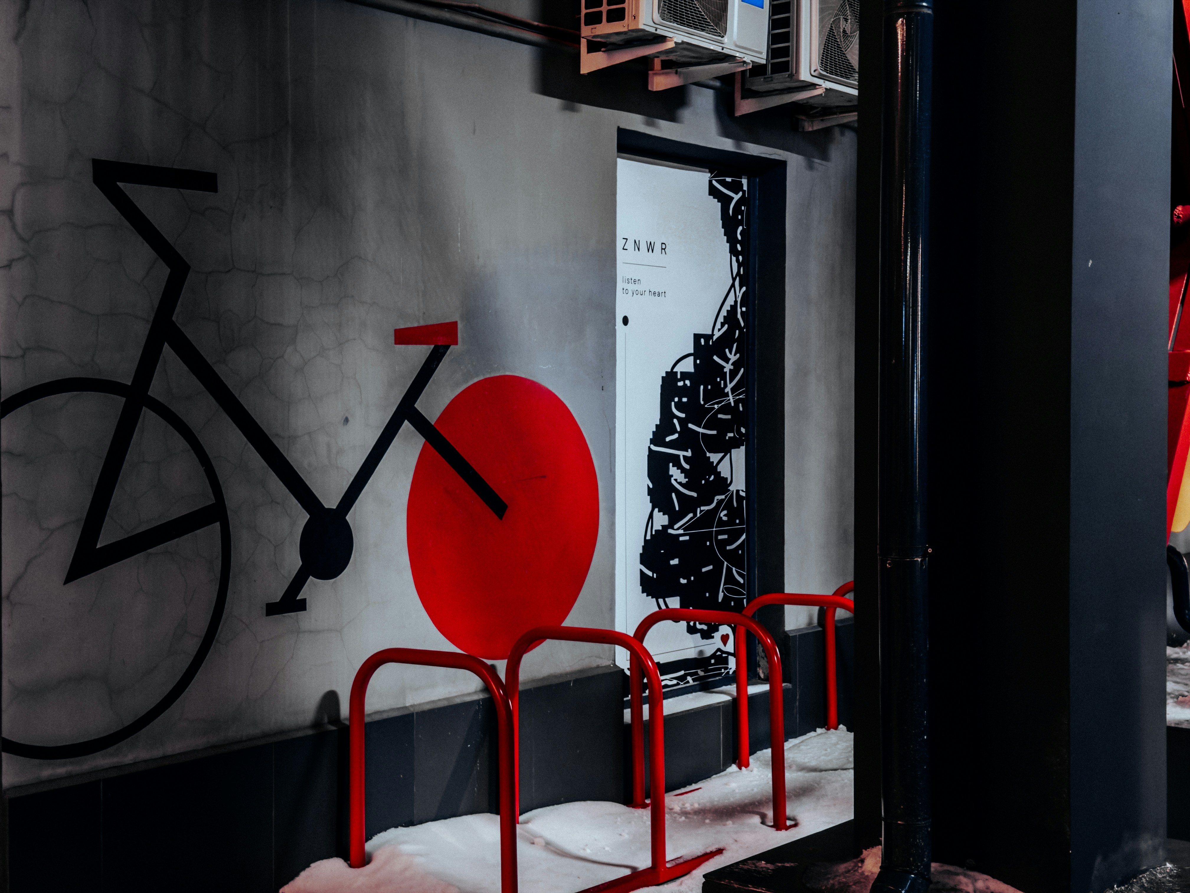 Red Bike Rack and Abstract Wall: Urban Scene with Shadow and Steel