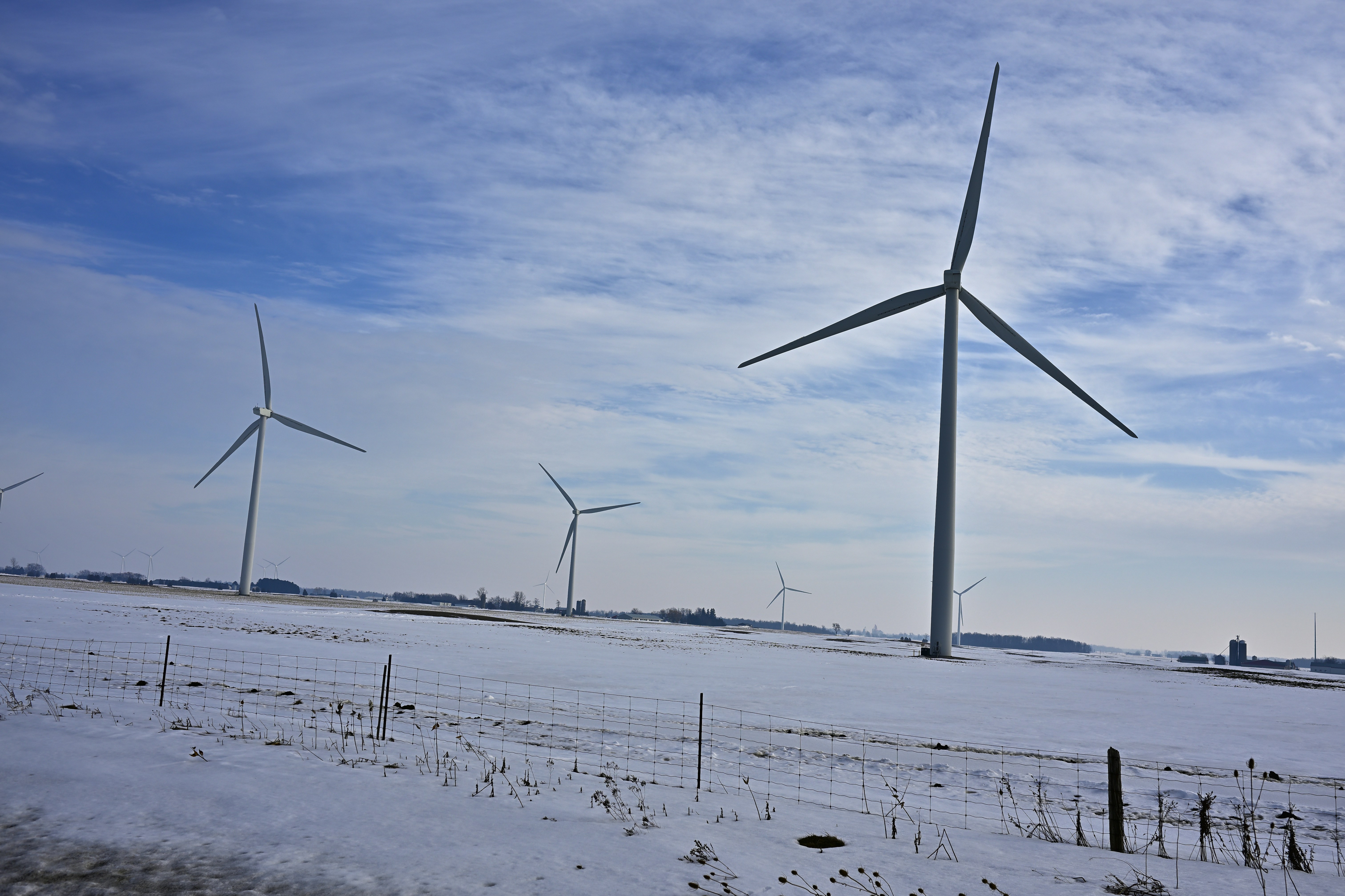Snow-Blanketed Plain with Towering Wind Turbines Under a Wide Sky