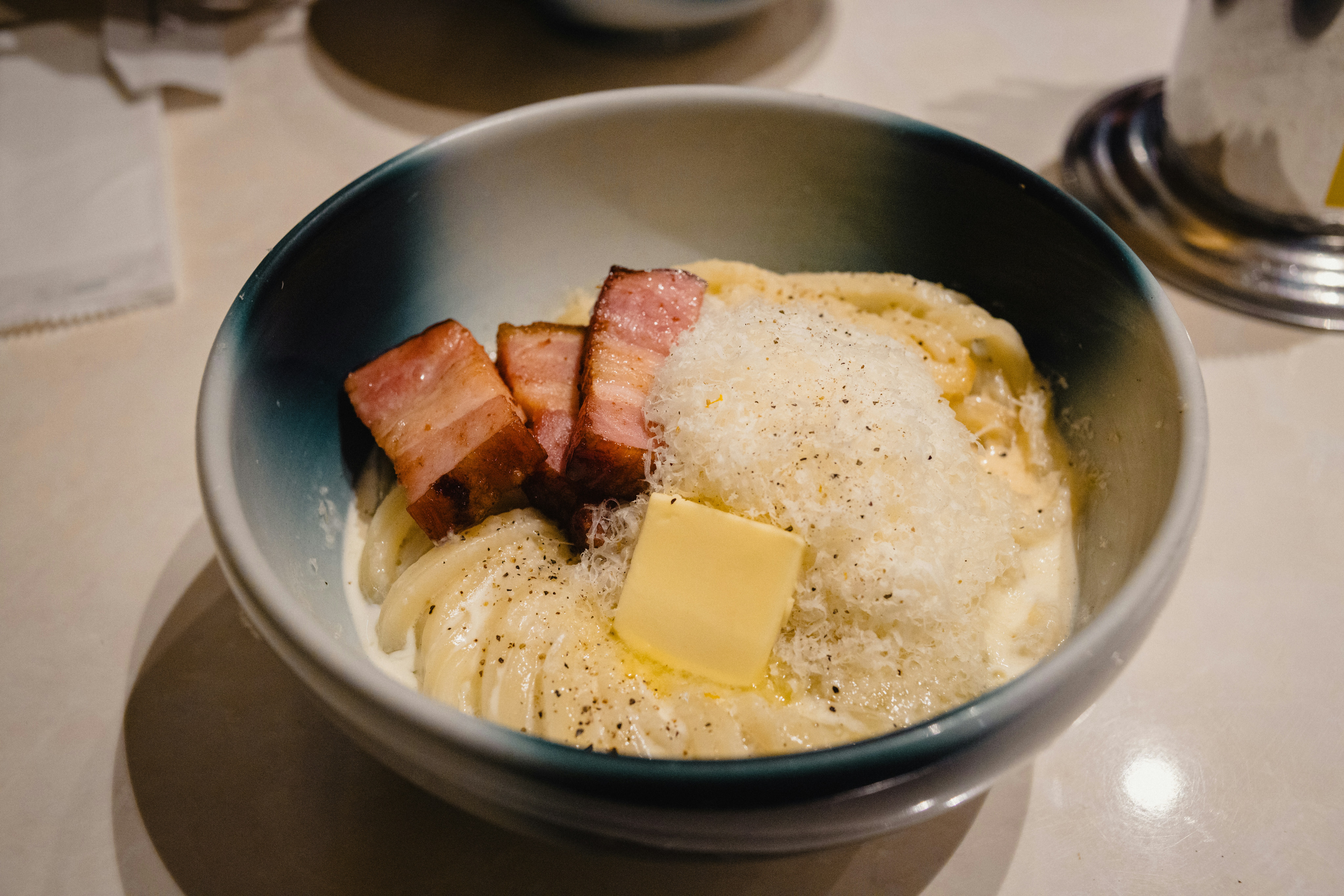Creamy bowl of macaroni with grilled bacon and buttered cornflakes