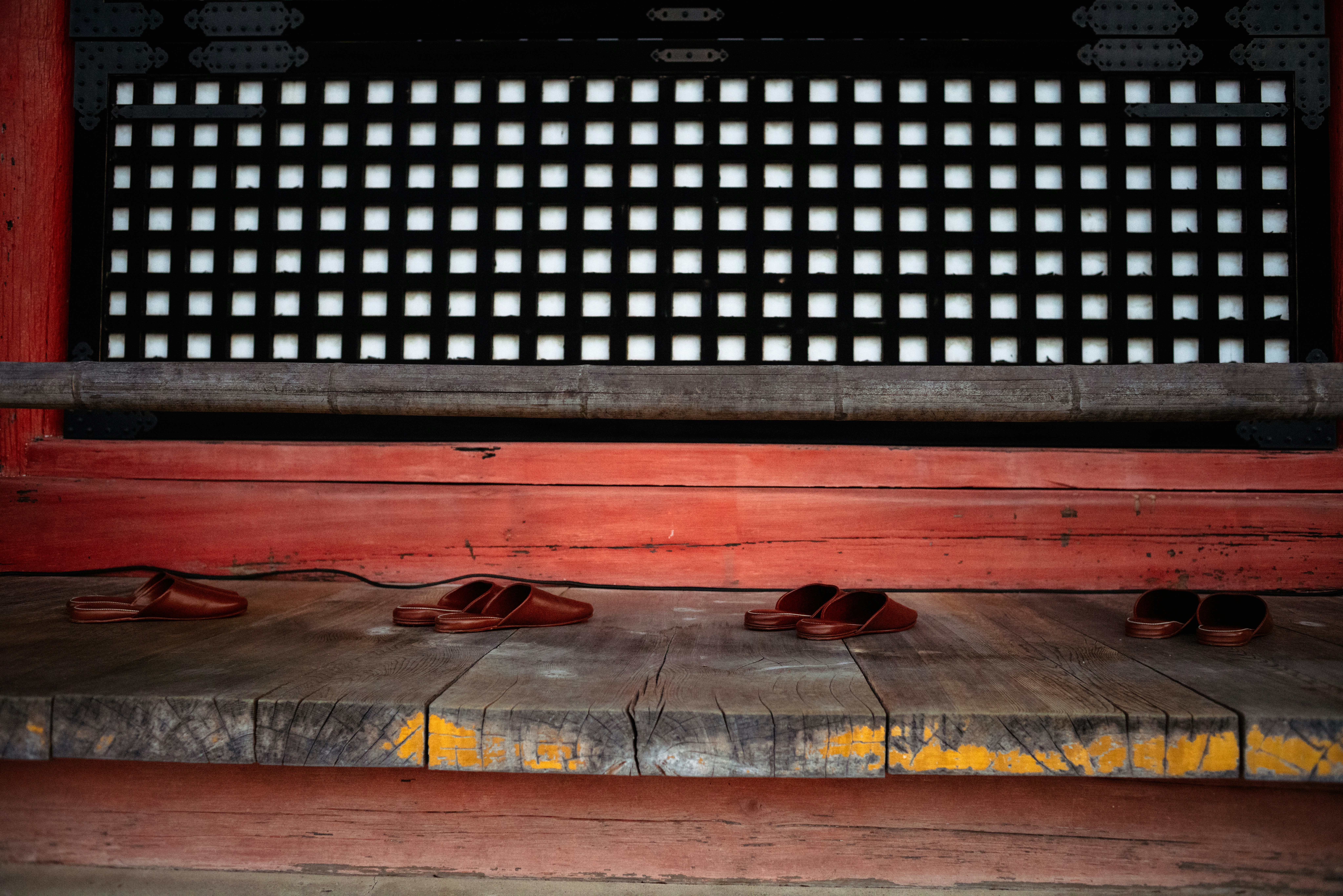 Silent Corridor of Shoes: A Red-Wood Bench after Sunset