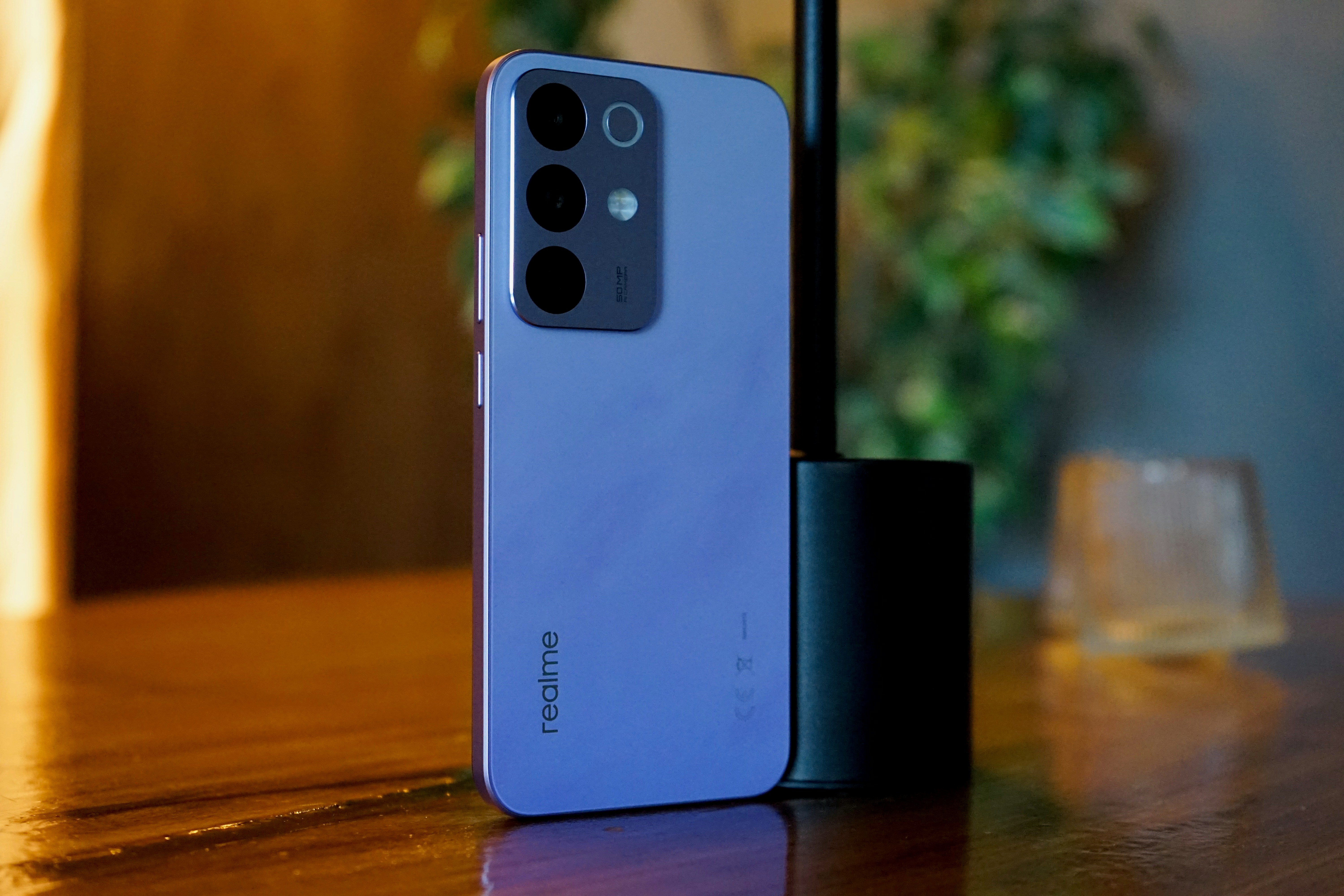 Blue Realme Smartphone Resting Upright on Wooden Desk