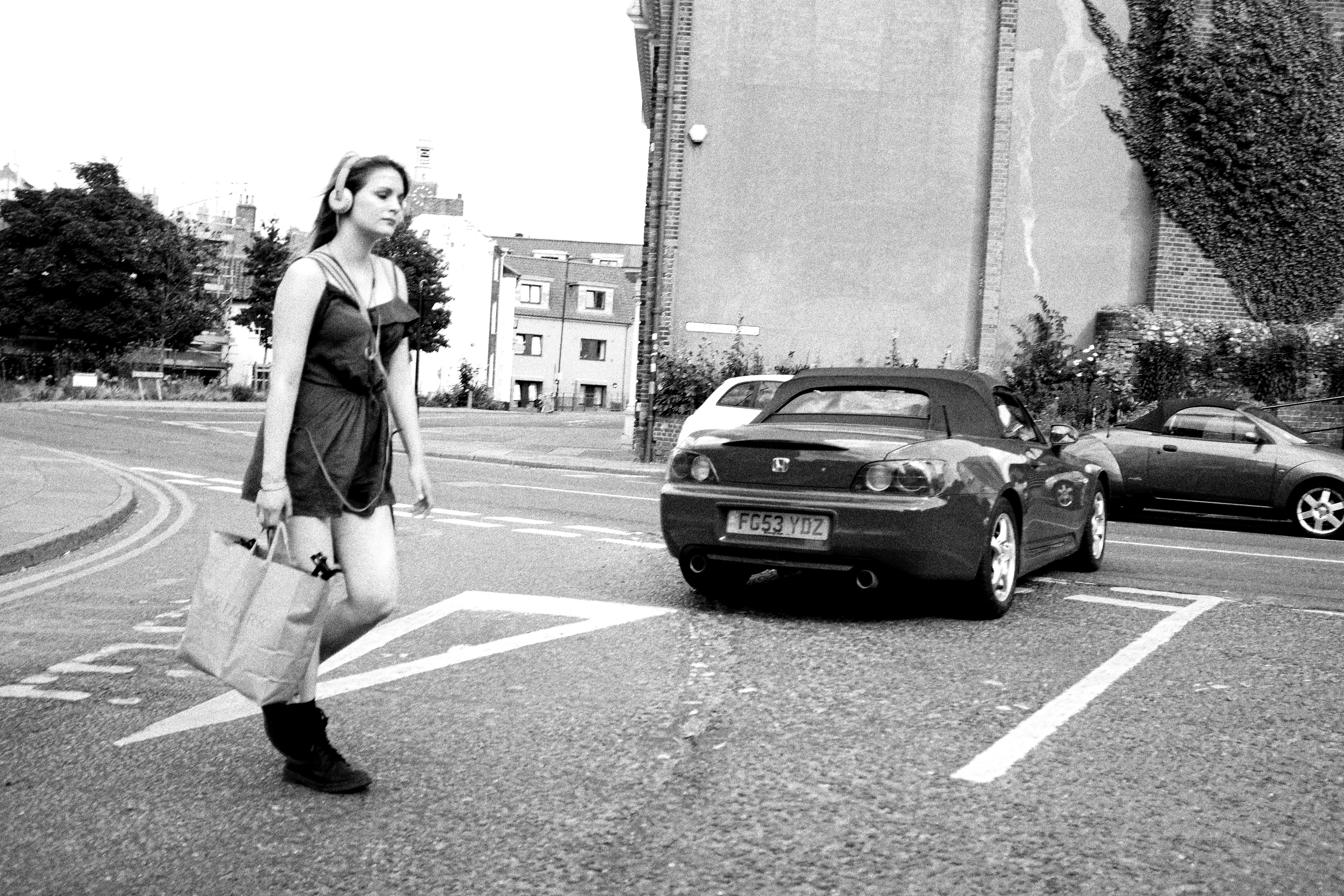Pedestrian Crosswalk Echo: A Woman in Motion Near a Parked Car