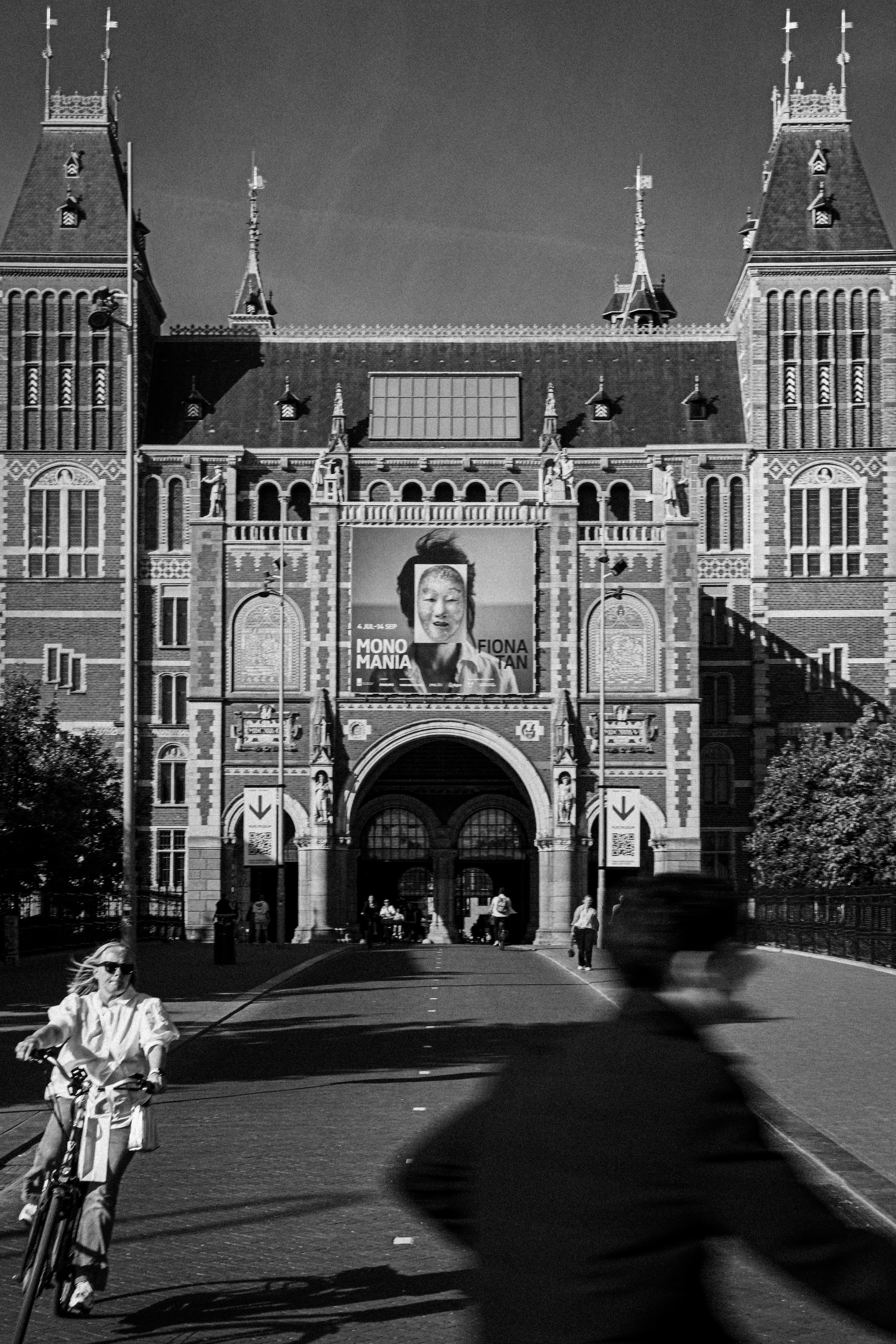 Gothic Gateways and a Passing Street: A Monochrome Moment in Amsterdam