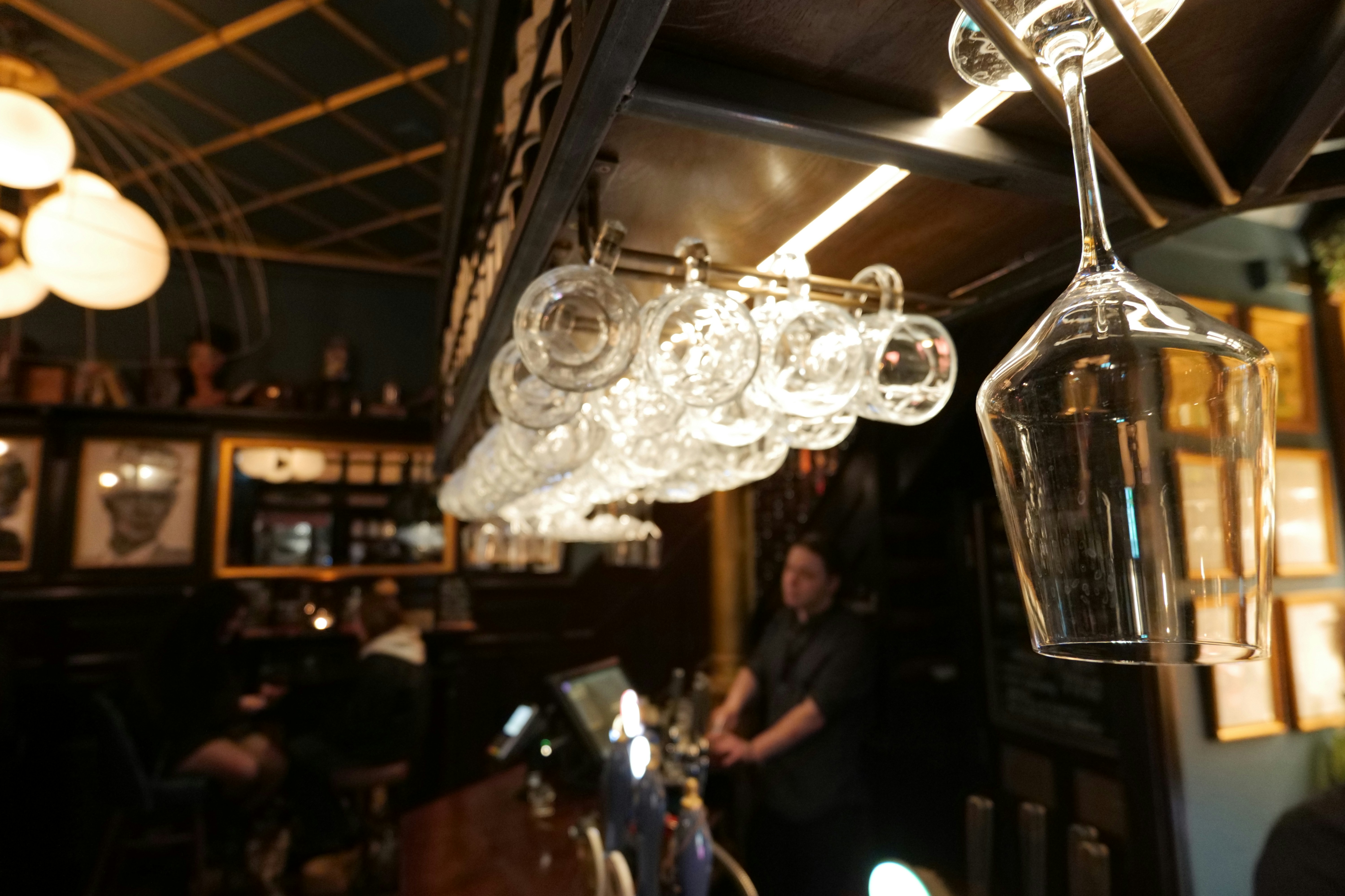 Hanging Glasses Over a Quiet Bar at Dusk