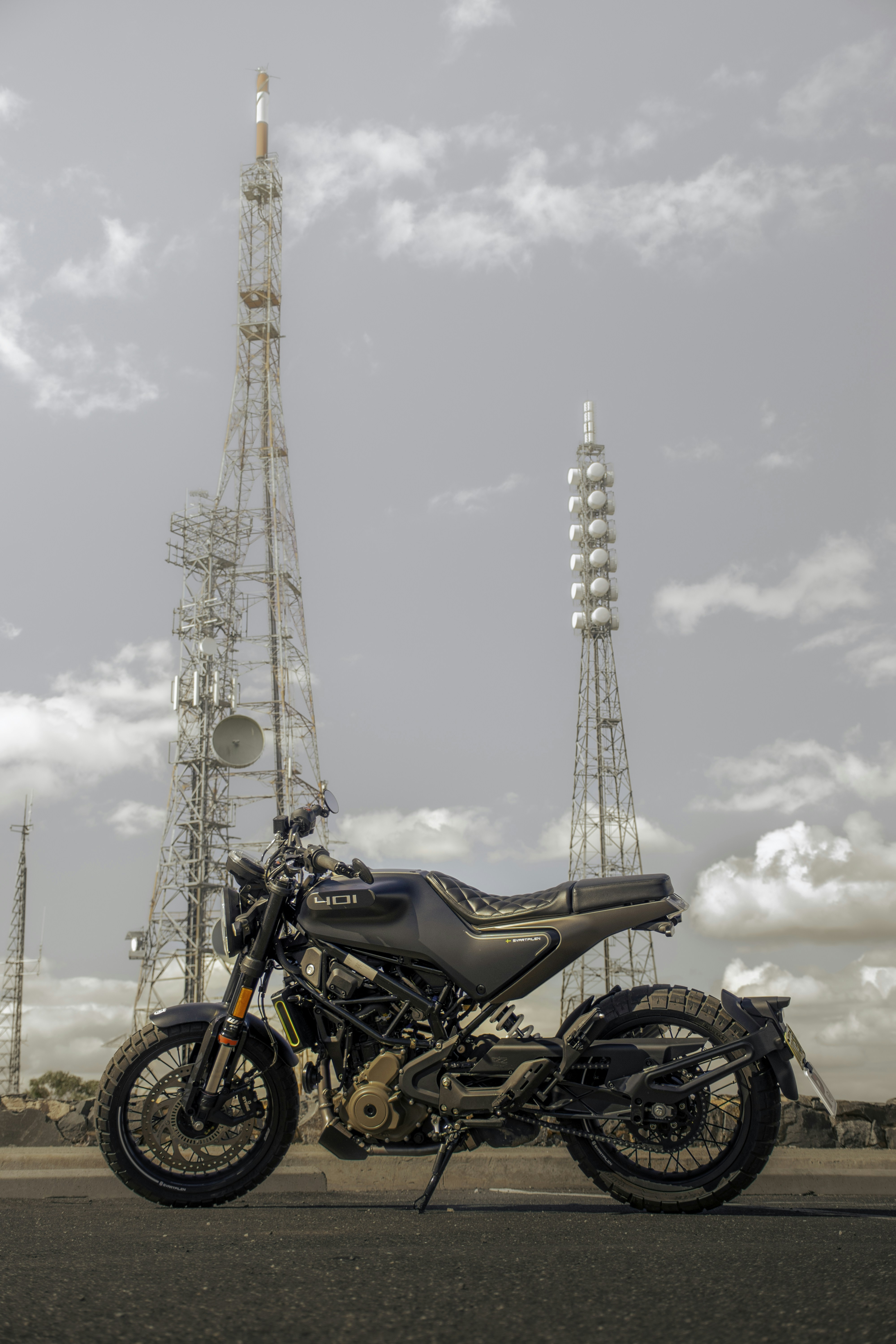 Urban Safari: A rugged Ducati-esque Scrambler Stands Tall Against Communication Towers
