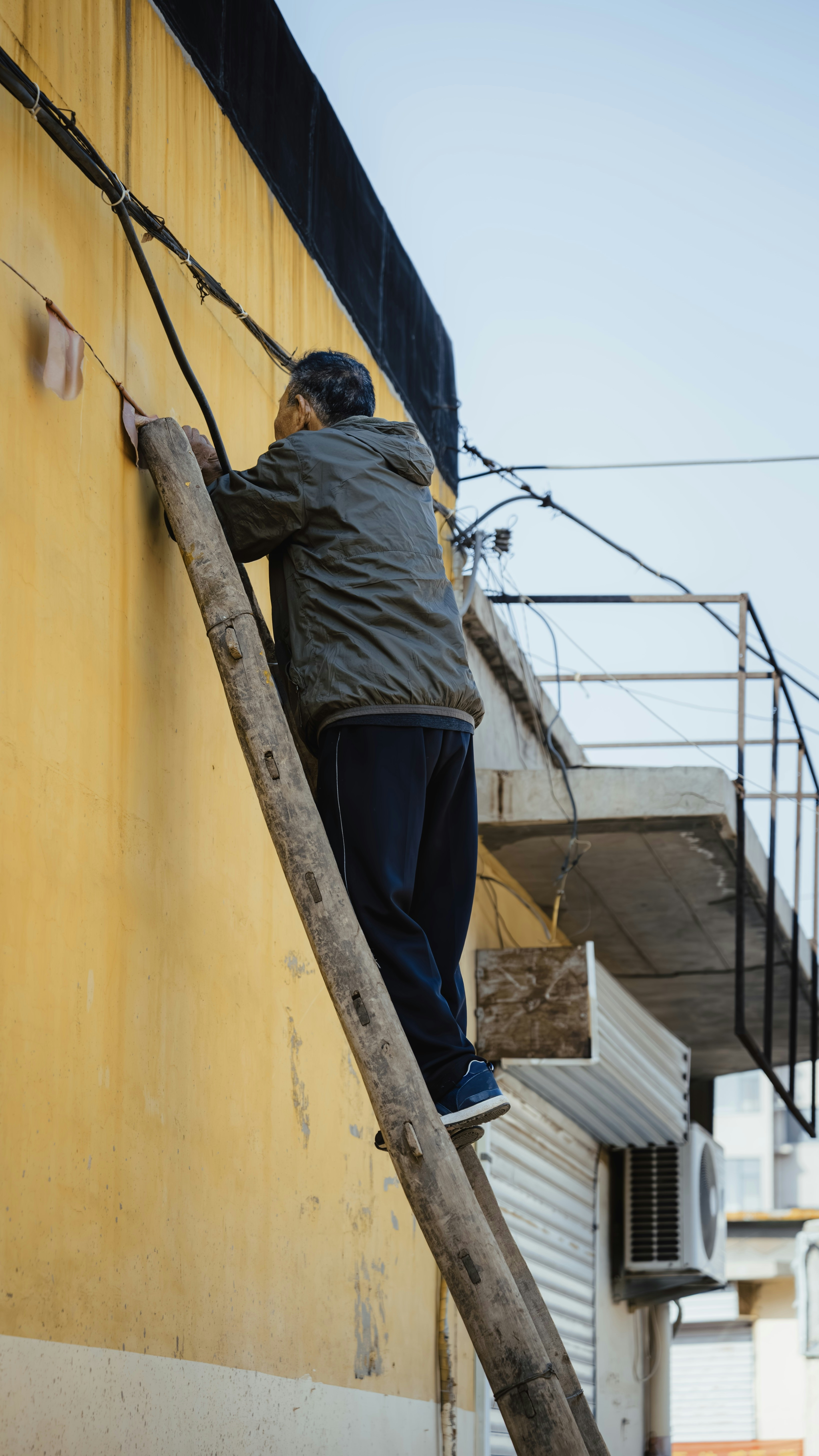 Climber on a Sunlit Yellow Wall: A Moment of Steady Ascent
