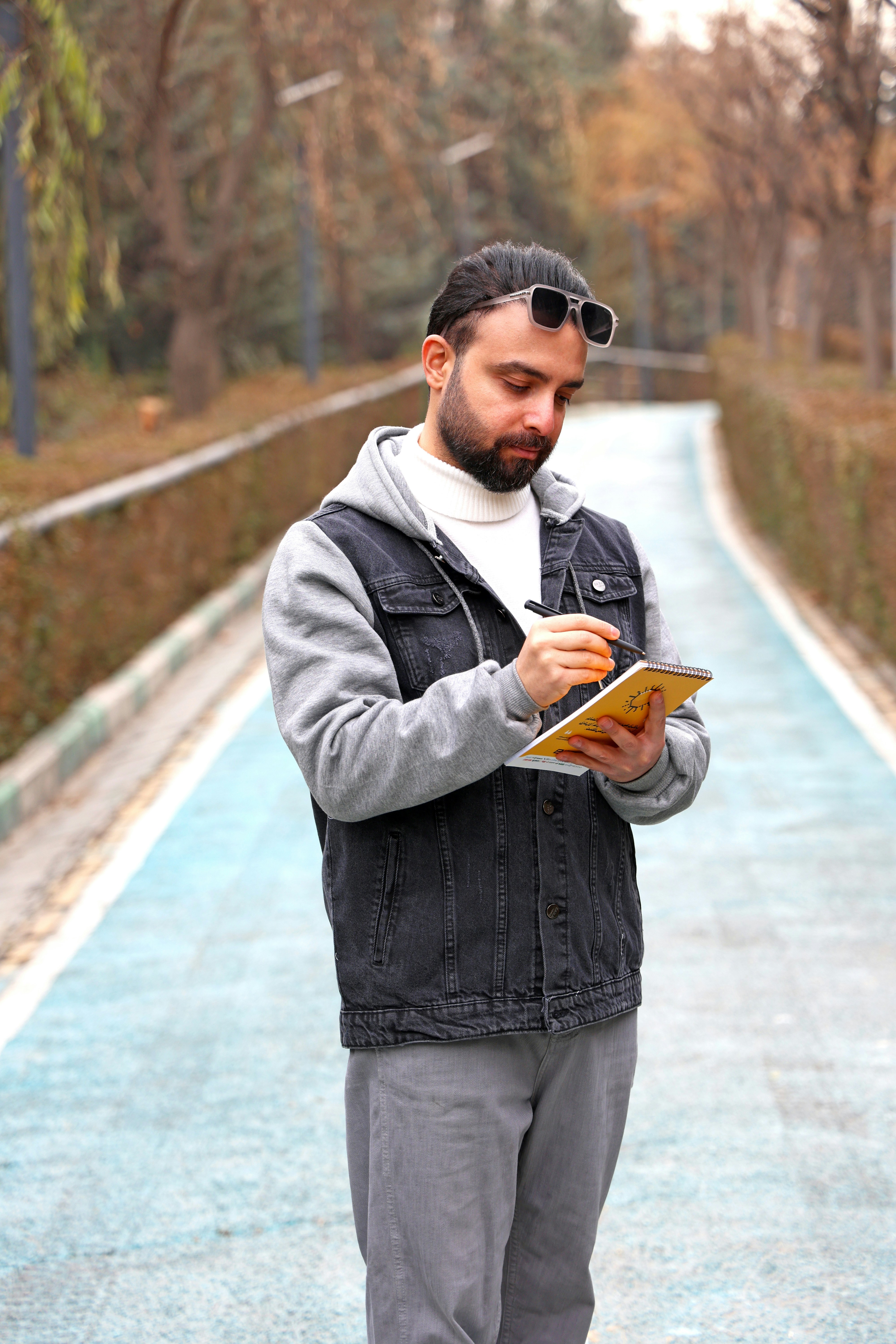 Notebook in Hand: A Solo Portrait on a Serene Park Path