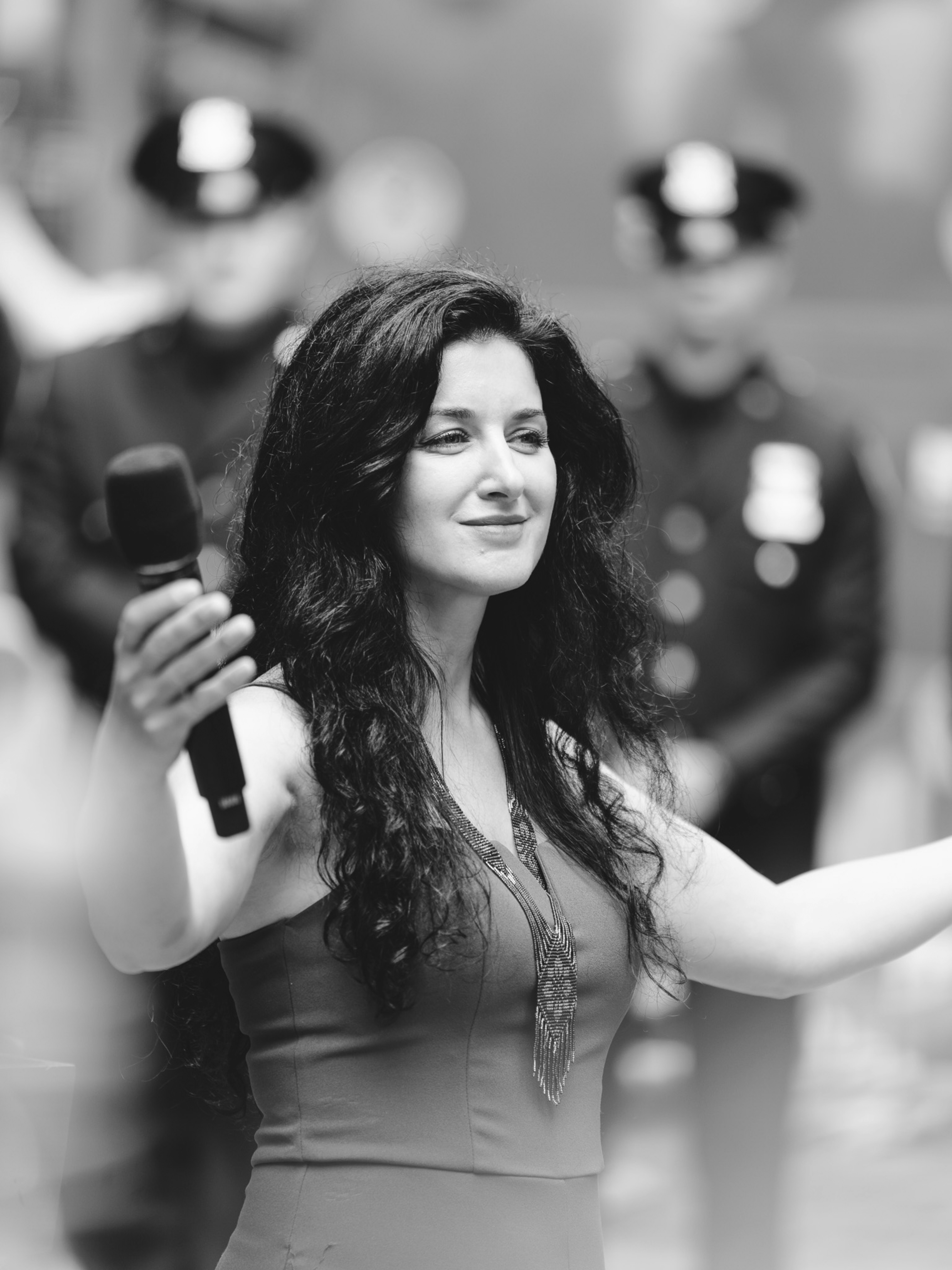 A confident vocalist frames a moment of applause amid a ceremonial backdrop