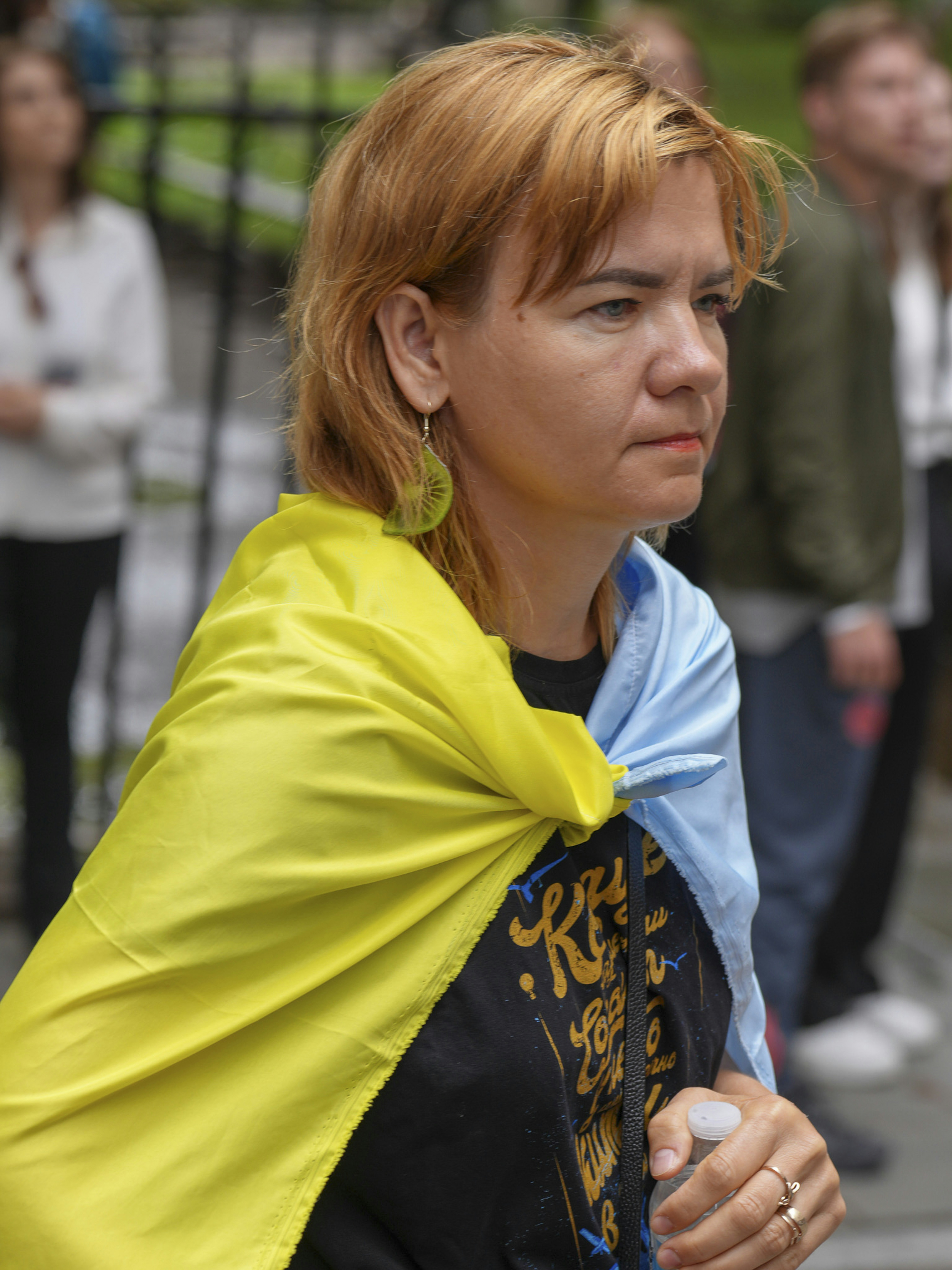 Yellow cloak, blue knot: a moment of quiet defiance in a crowded park