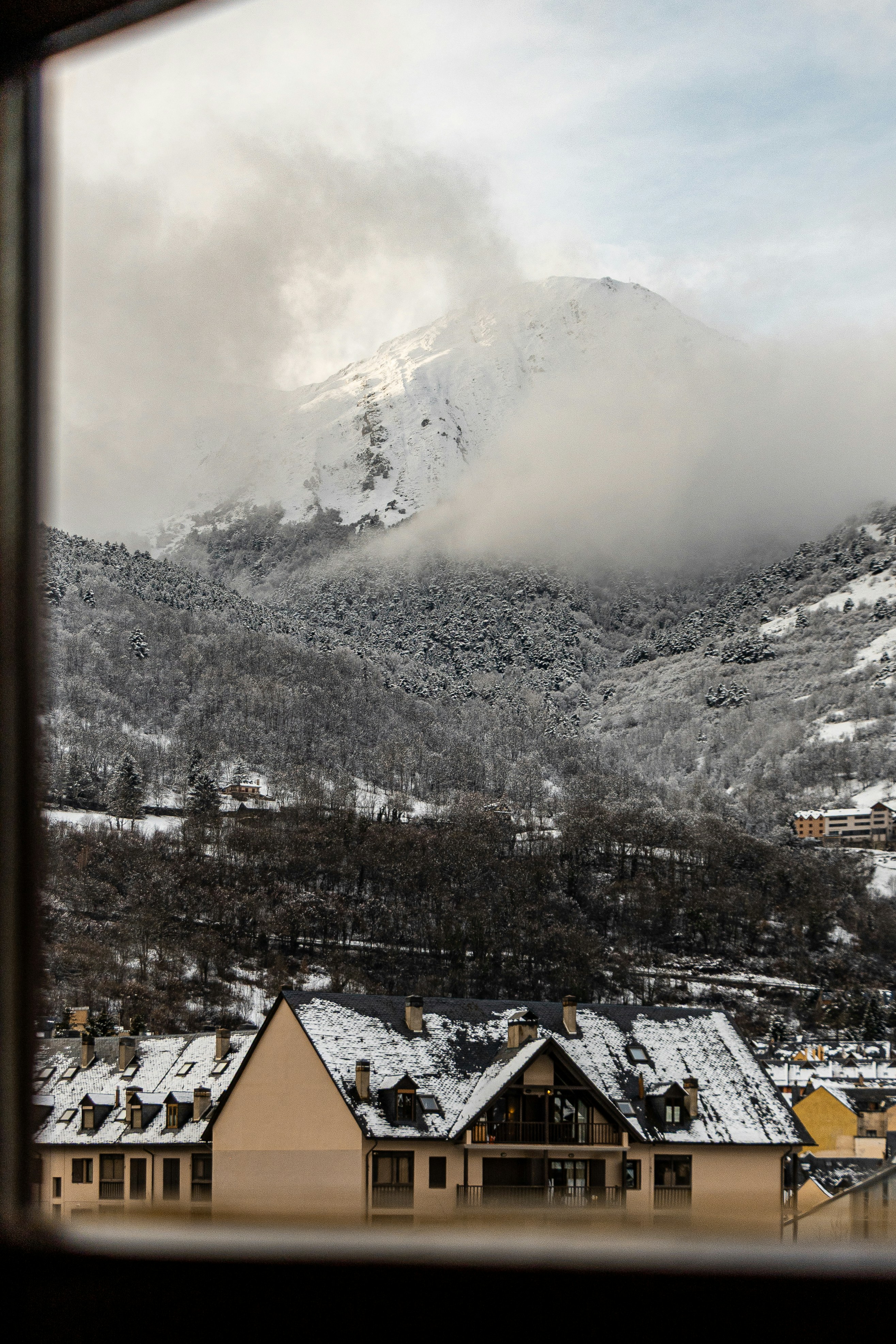 Snow-kissed Chalets Framed by Mountain Veil