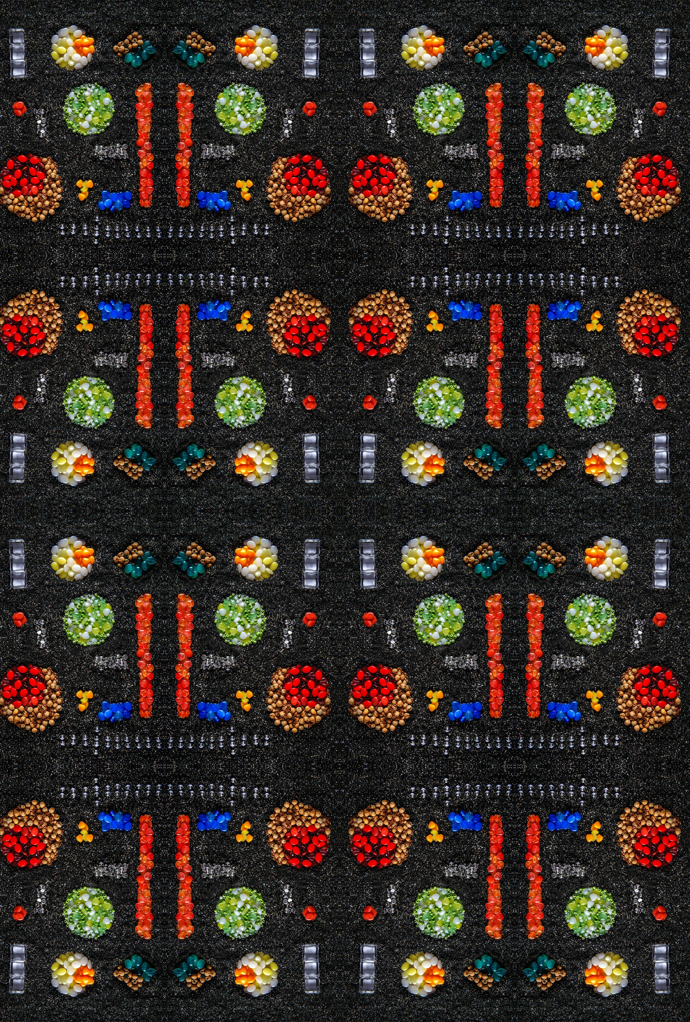 Symmetrical array of vibrant snack clusters arranged in repeating patterns on a dark surface. A graphic, tiled composition with emphasis on color and texture rather than a central subject.