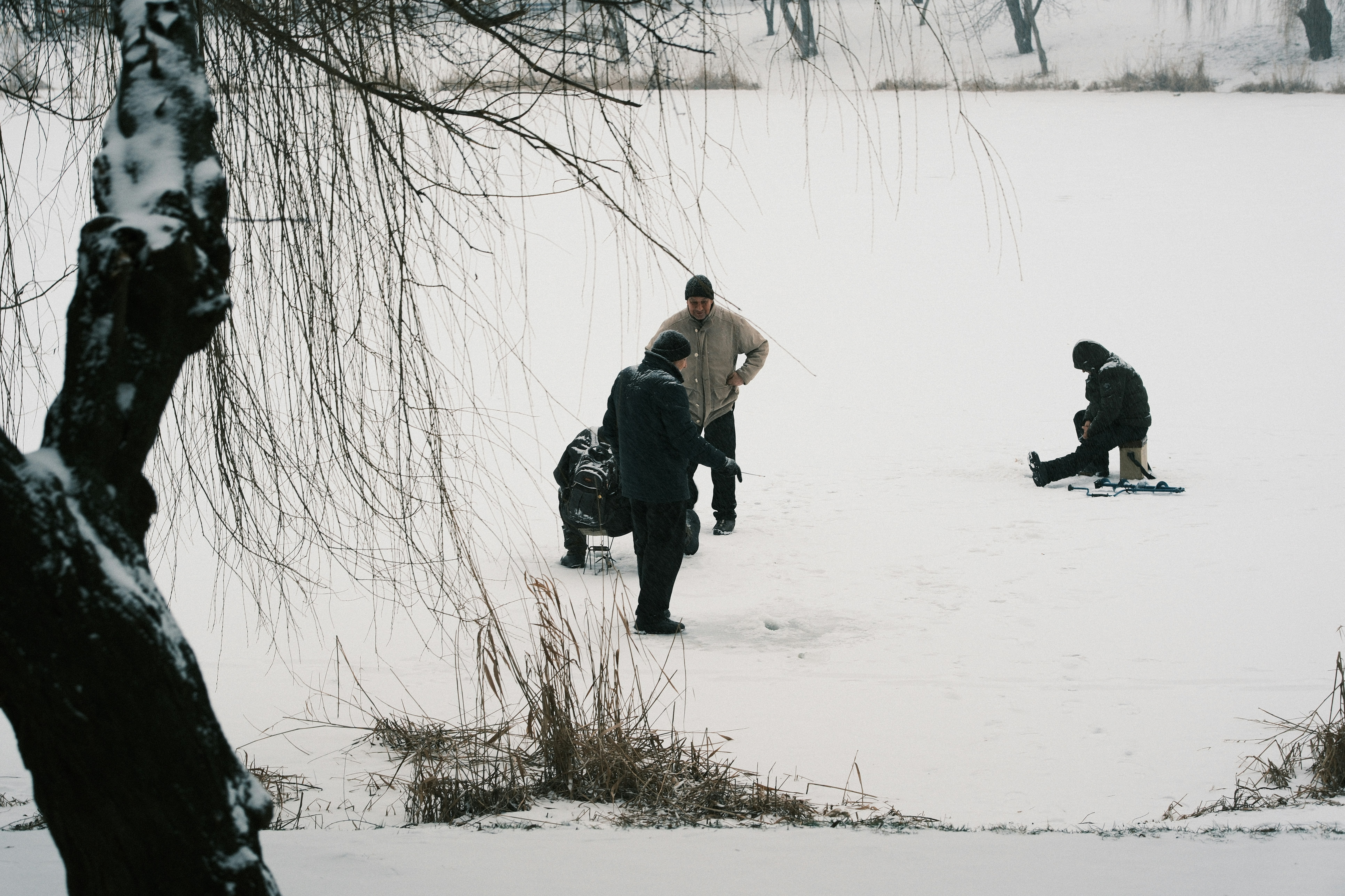 Winter Schoolyard in Focus: Snow-Covered Figures at the Pond