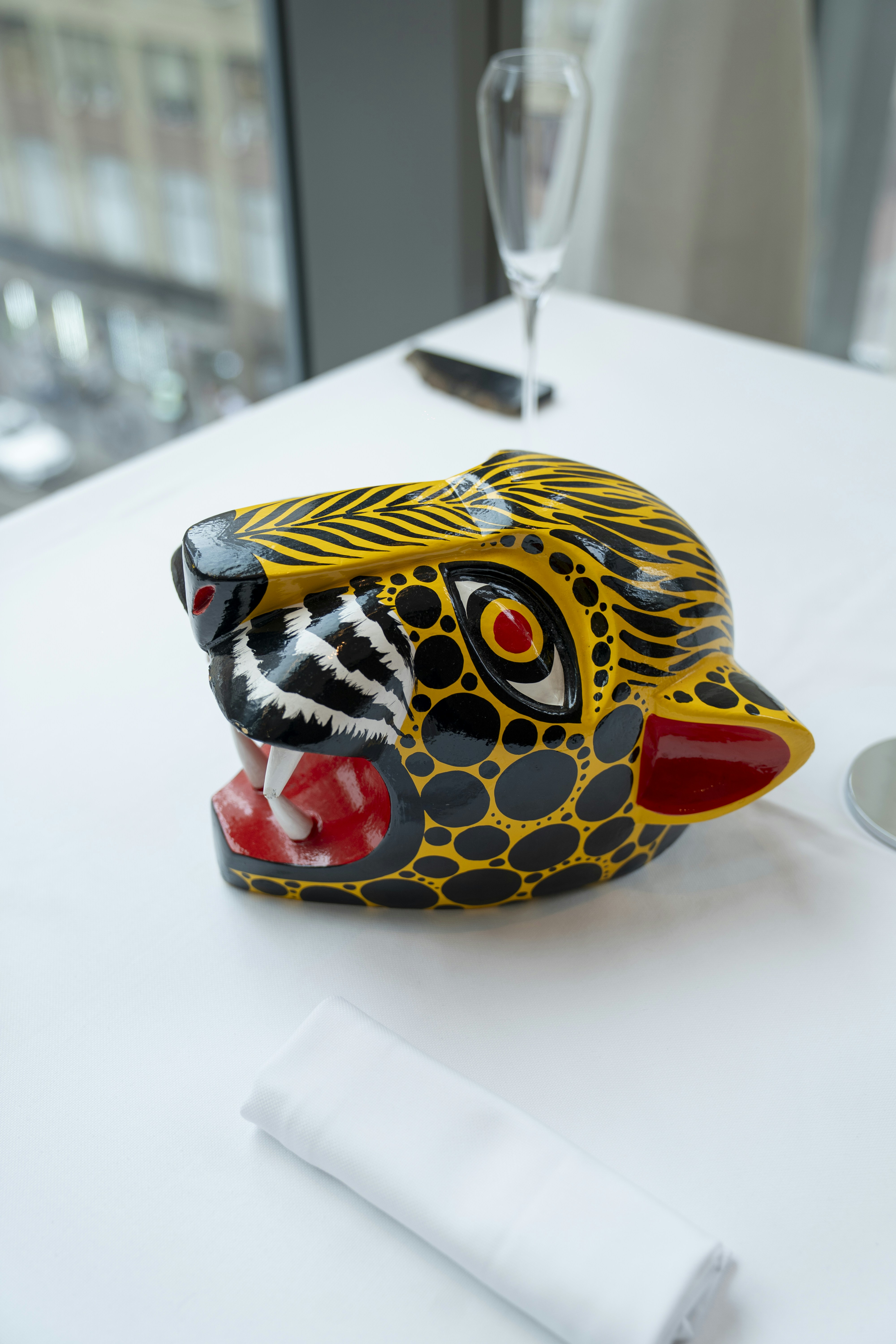 Tiger Mask on a White Table: A Bright ceramic Carving Surfaces in Focus