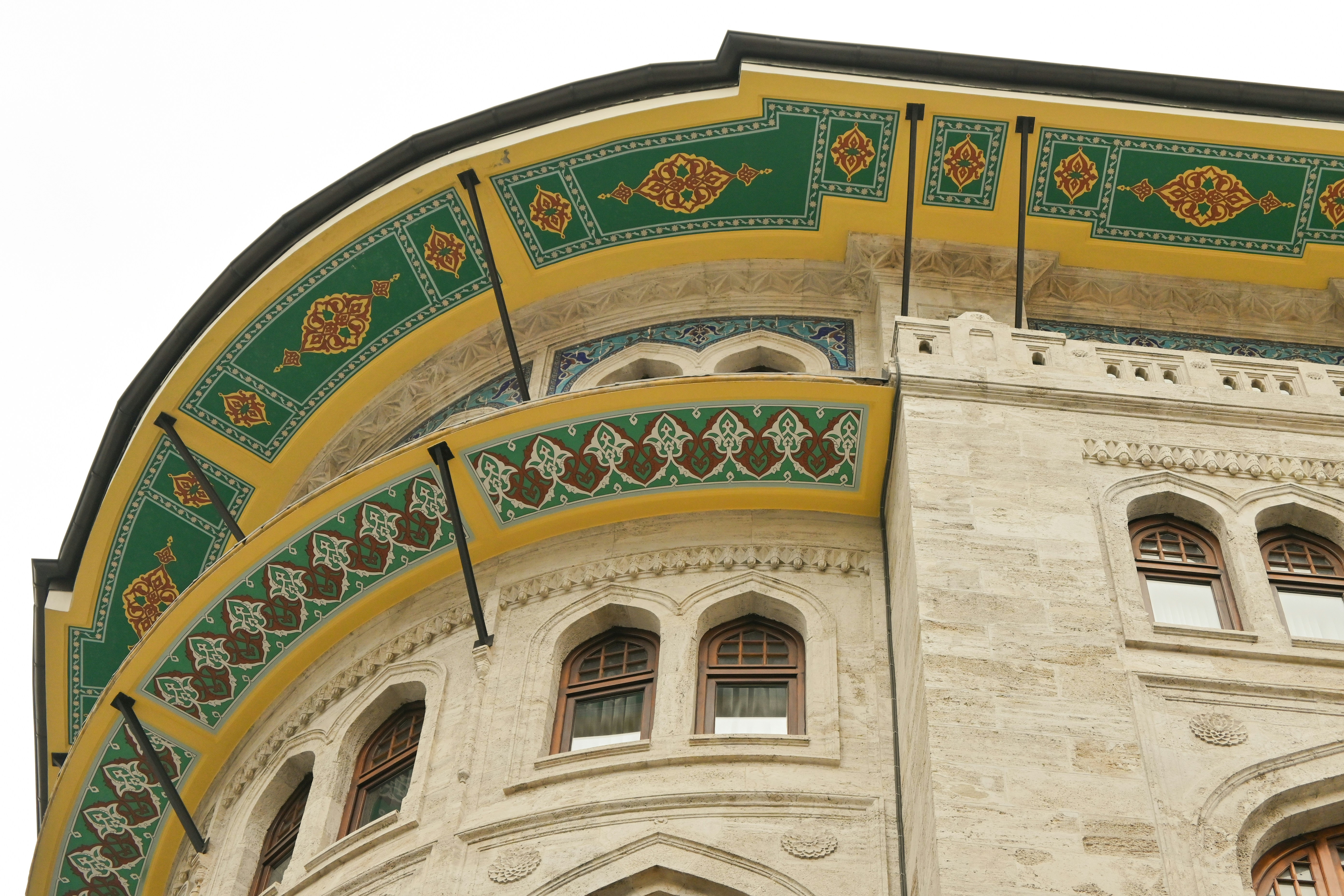 Ornate Arch Overlook: A Carved Green-and-Gold Detailing Crowning a Stone Facade