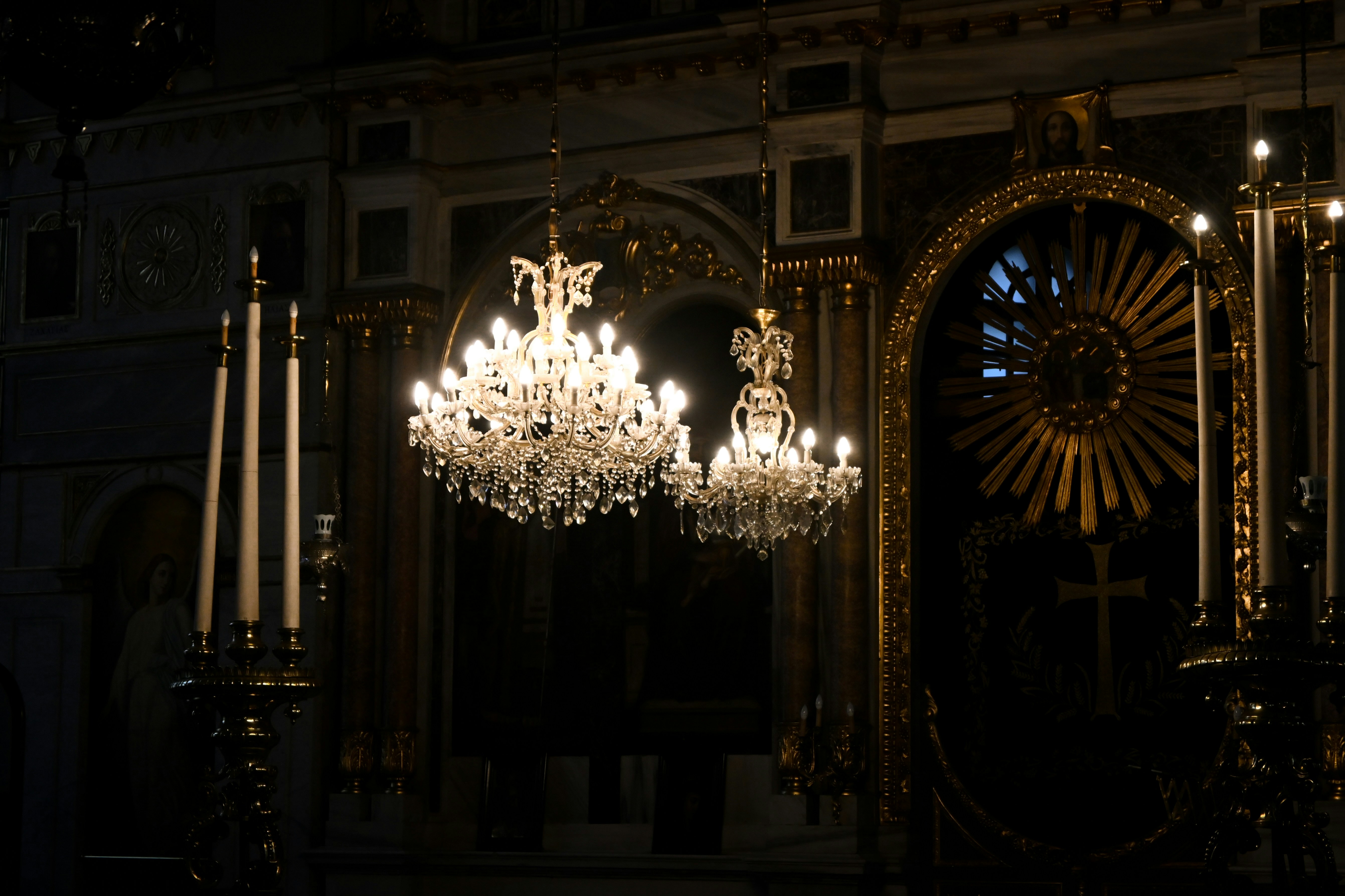 Crystal Glow Amid Sacred Shimmer: Chandelier and Icon in Evening Chapel