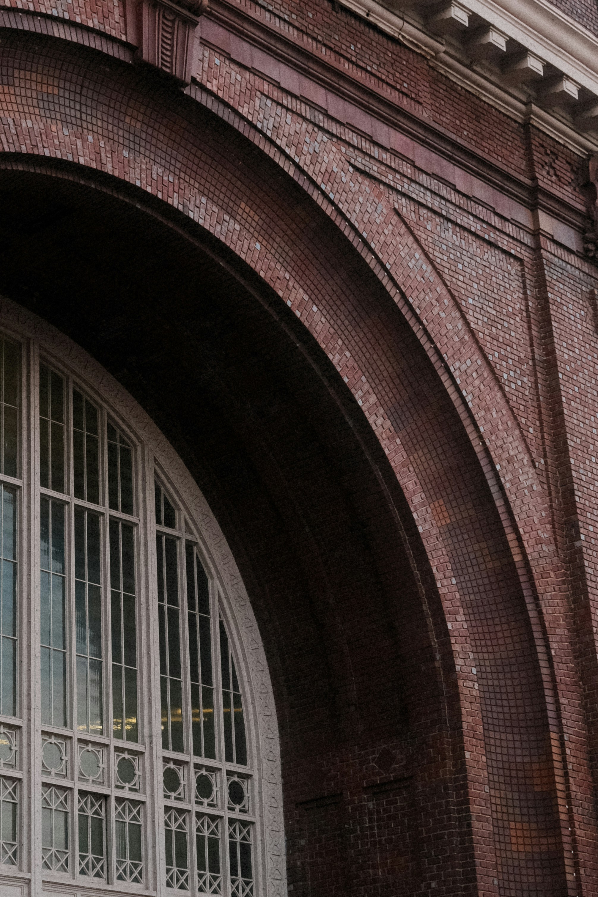 Brick Archways and Sunlit Window: A Quiet Urban Facade