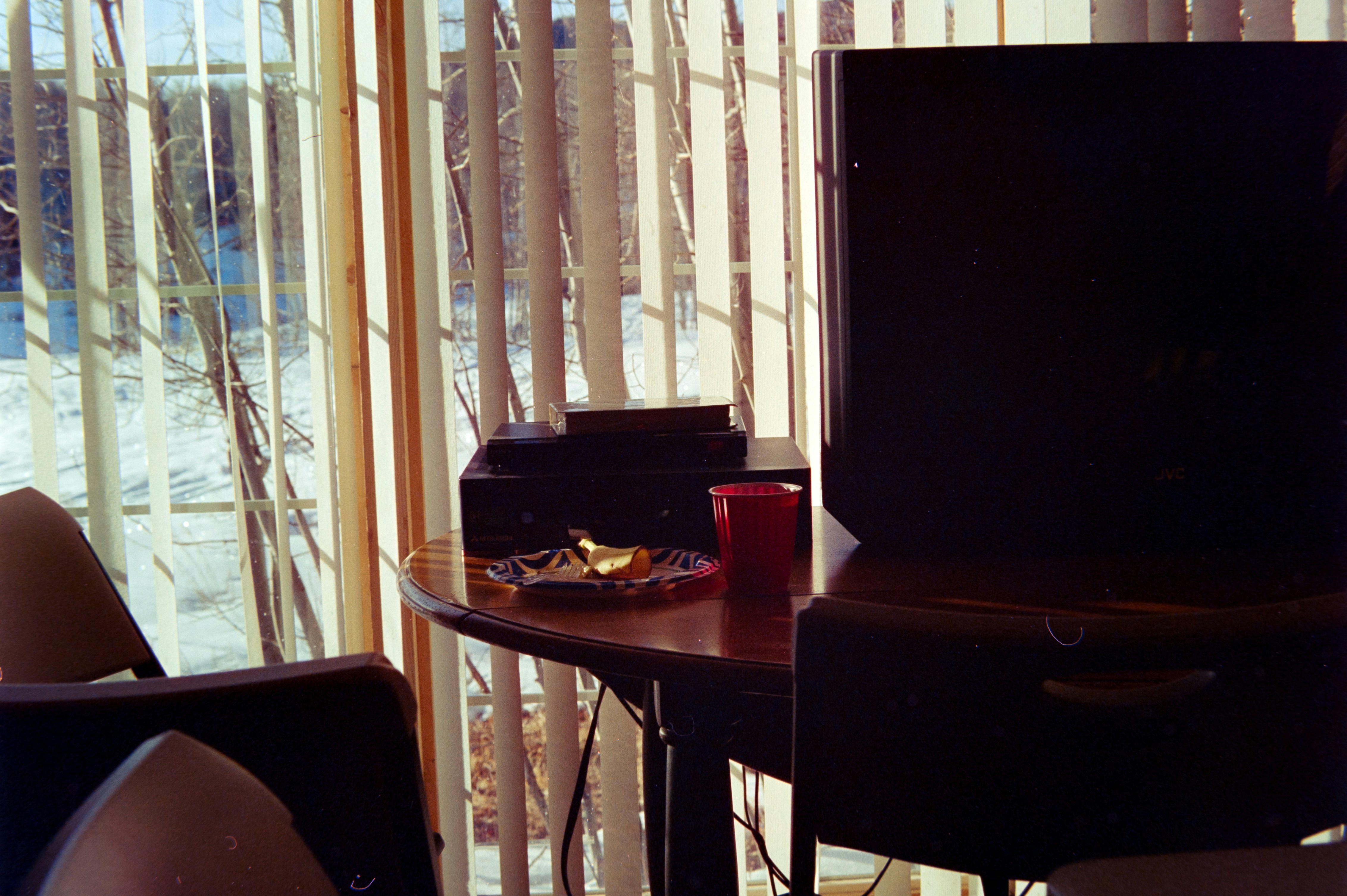 Sunlit Office Nook: A Glass of Red and a TV Stand by the Window