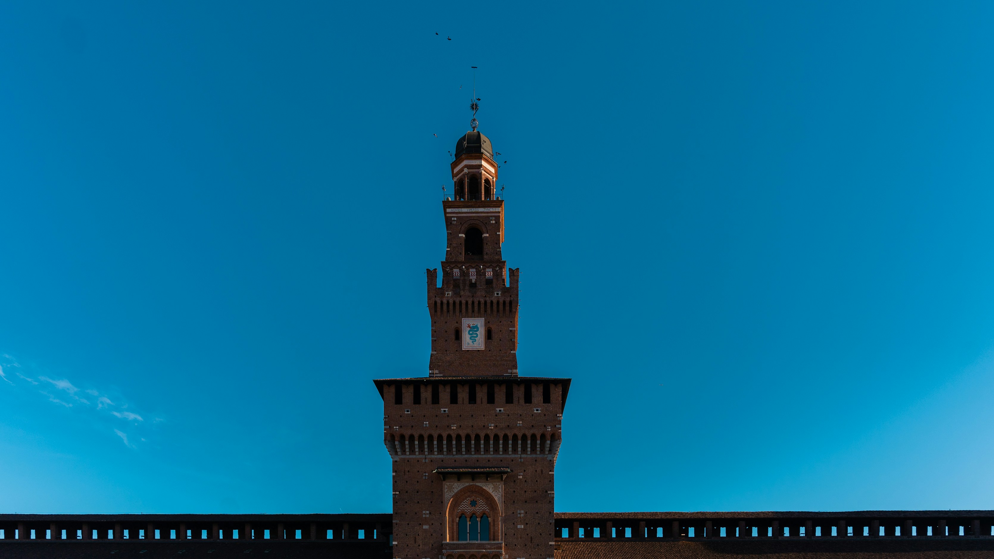 Towering Geometry: The Clockwork Facade Beneath a Clear Sky