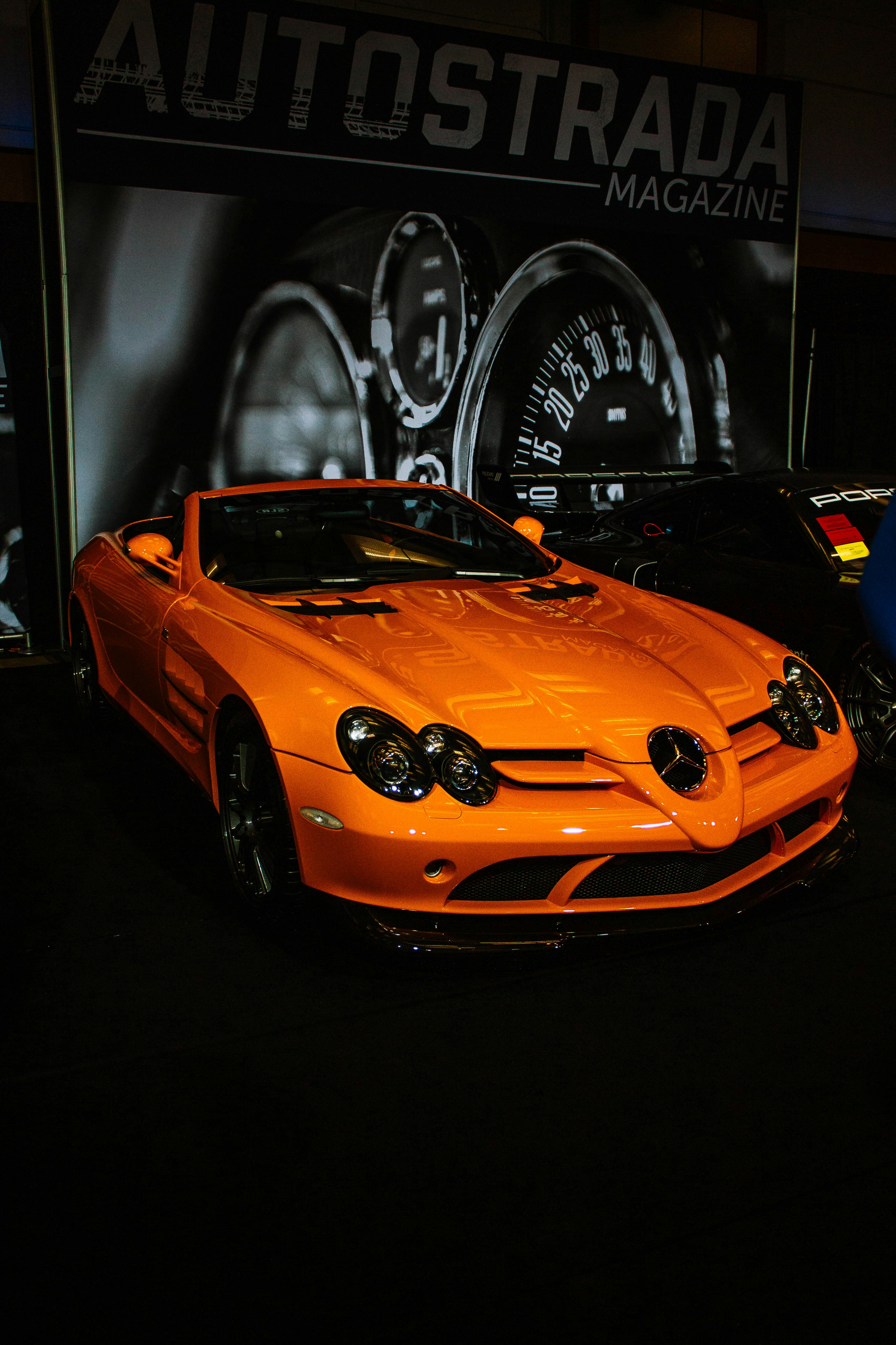 Orange Mercedes at the Auto Show: Bold Vibes under Dim Spotlight
