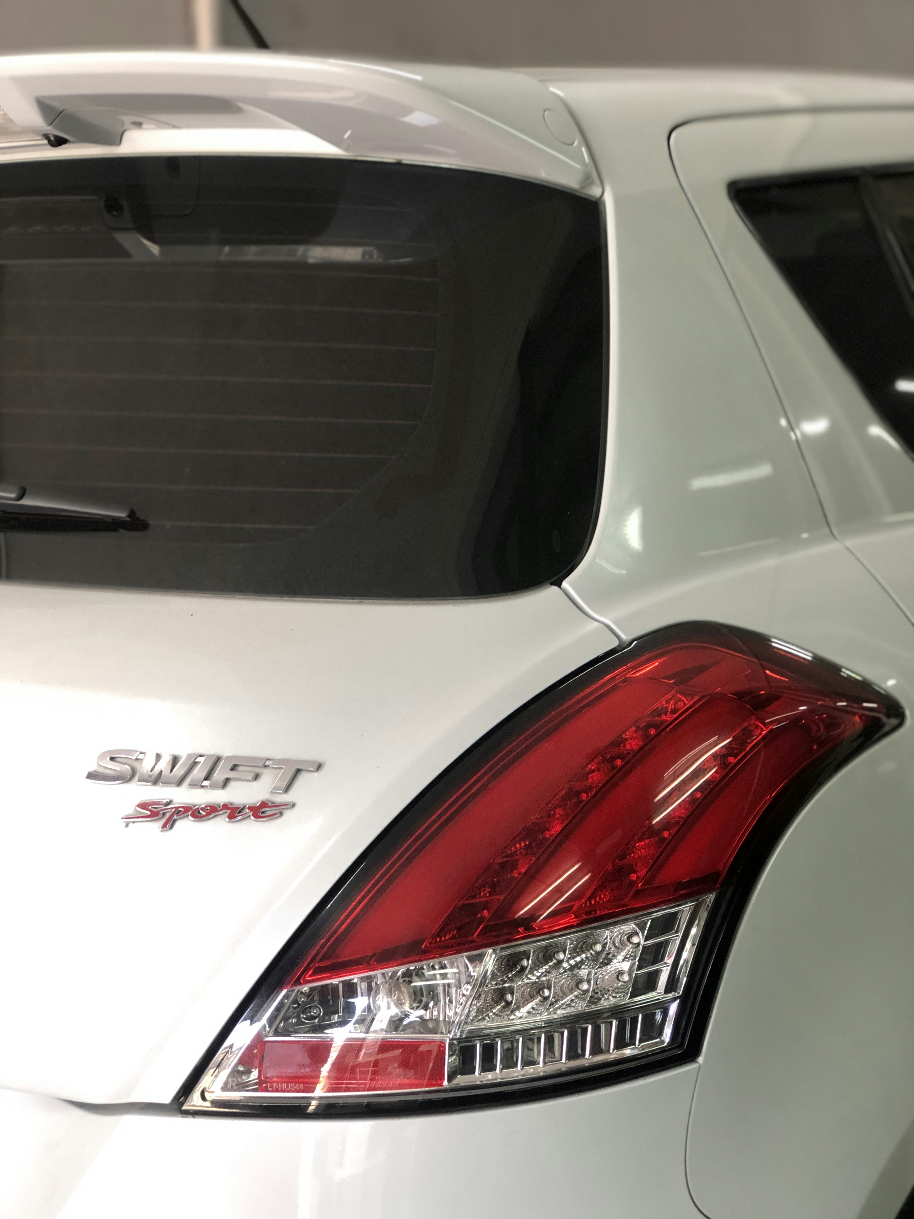 Rear Quarter View of a Swift Sport: Curved Tail Light and Hidden Badge