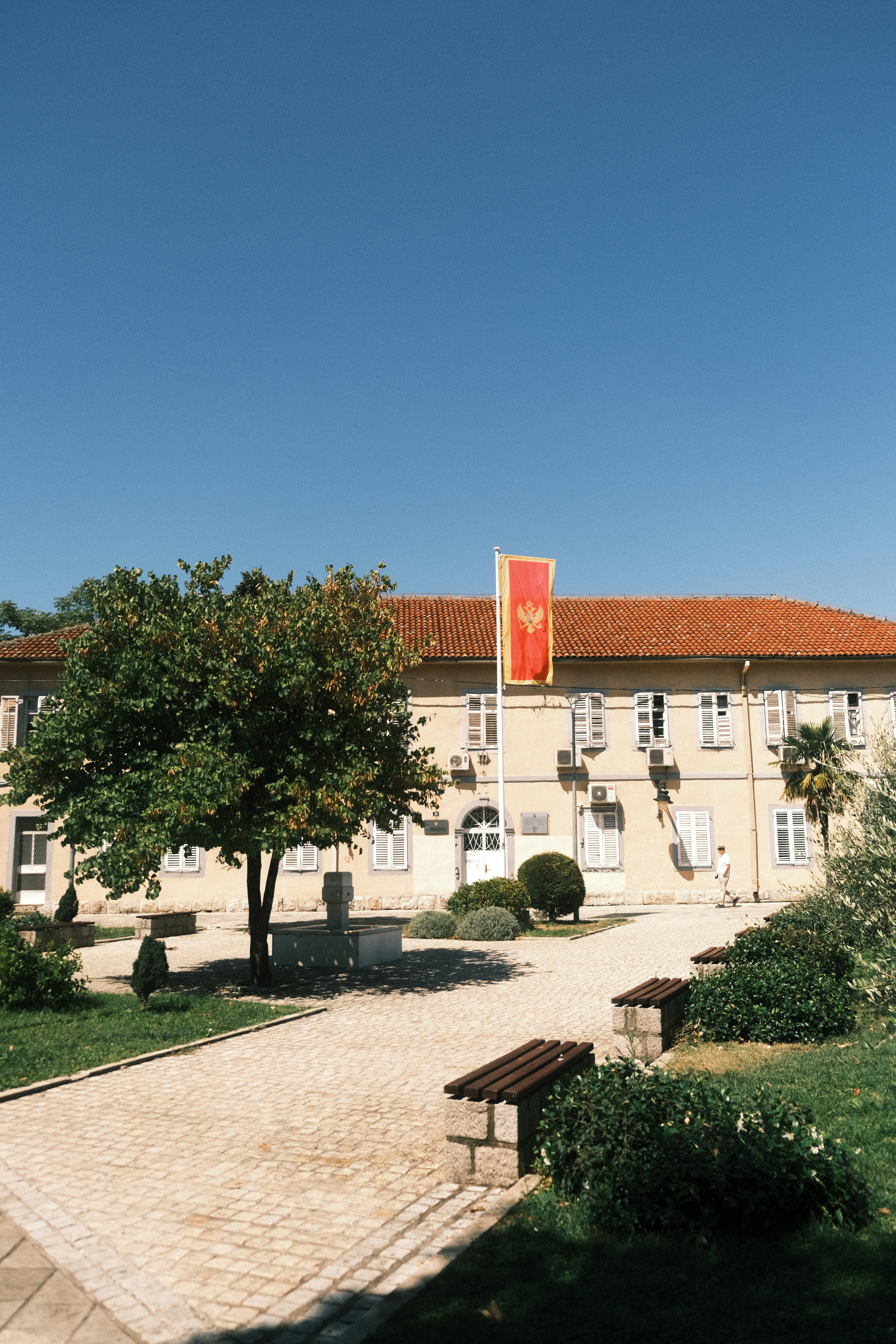 Flag over the sunlit courtyard of a historic stone building