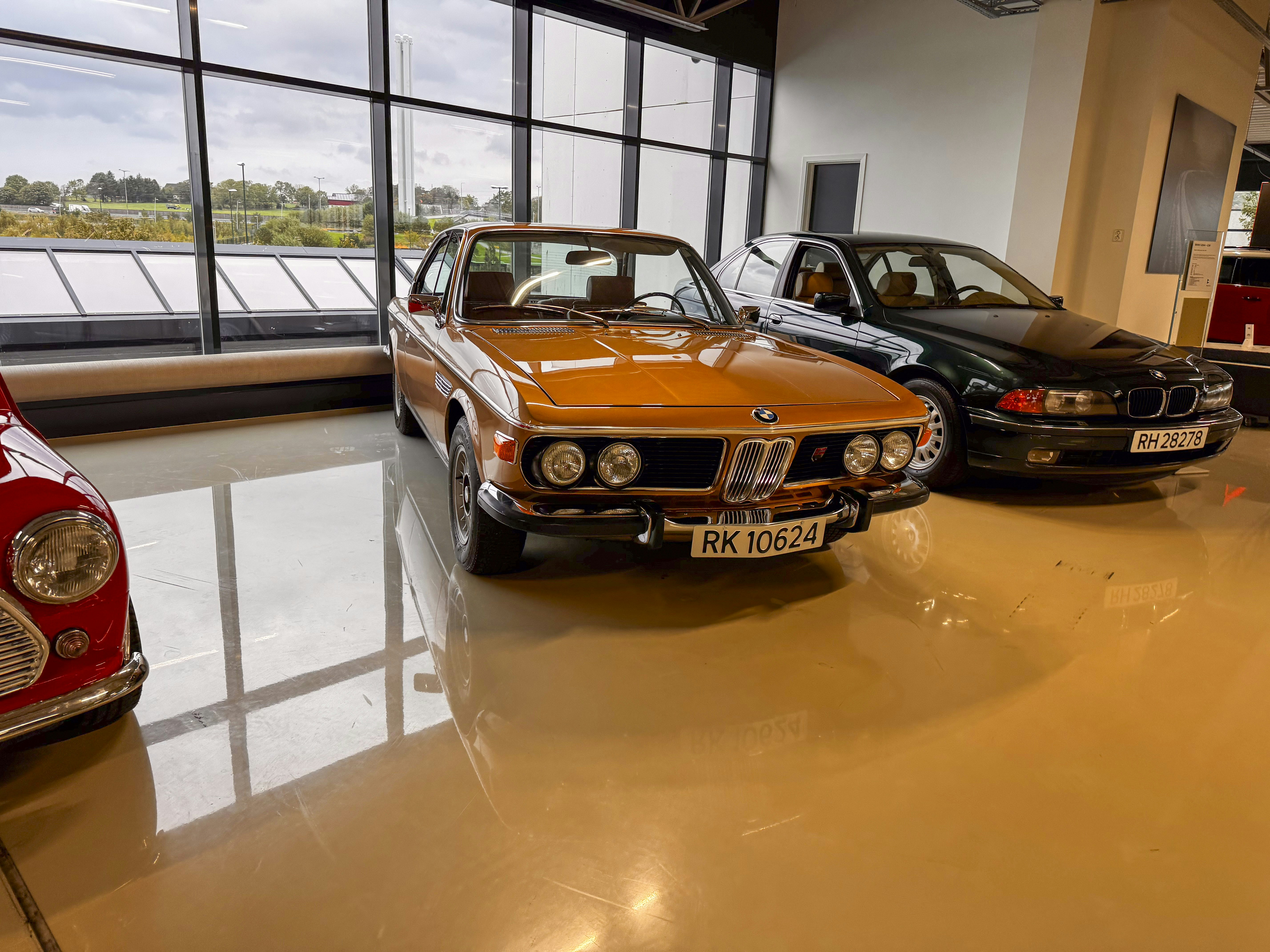 Sunlit Classic Corner: Vintage BMWs in a Modern Showroom