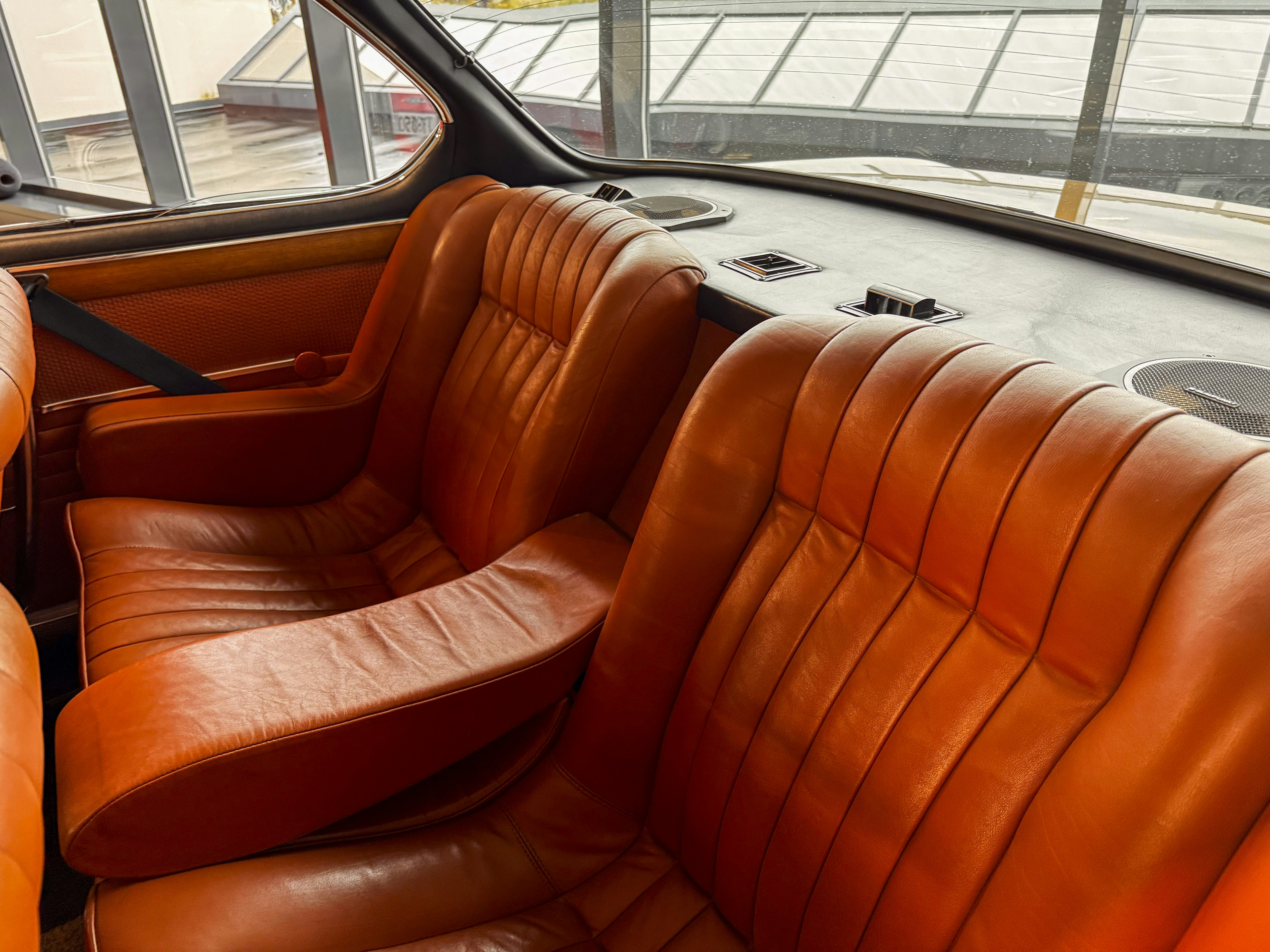 Warm Carriage: Orange Leather Seats Bathed in Sunlit Cab Interior