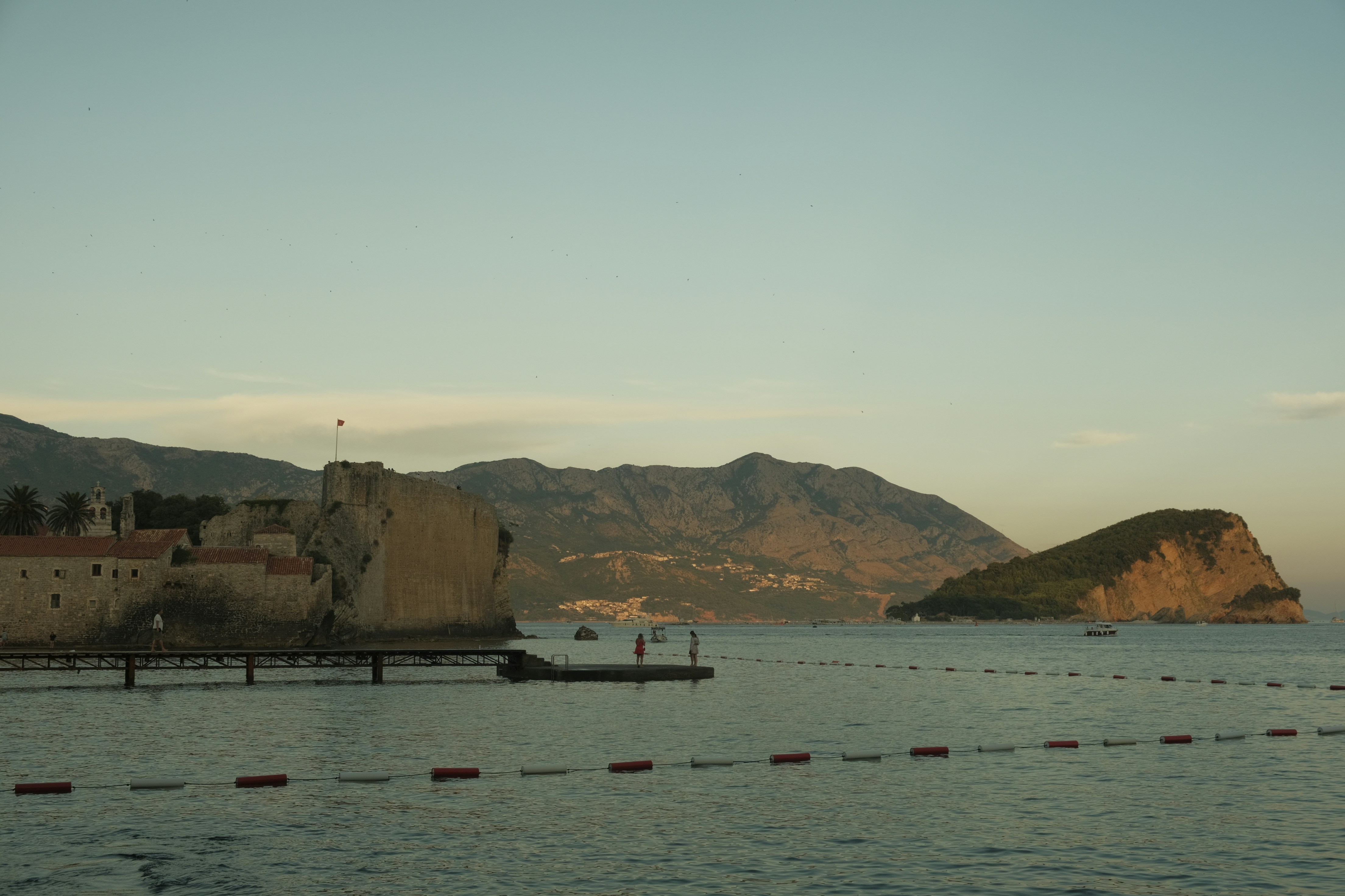 Harbor Walls at Dusk: Quiet Sea and Distant Hills