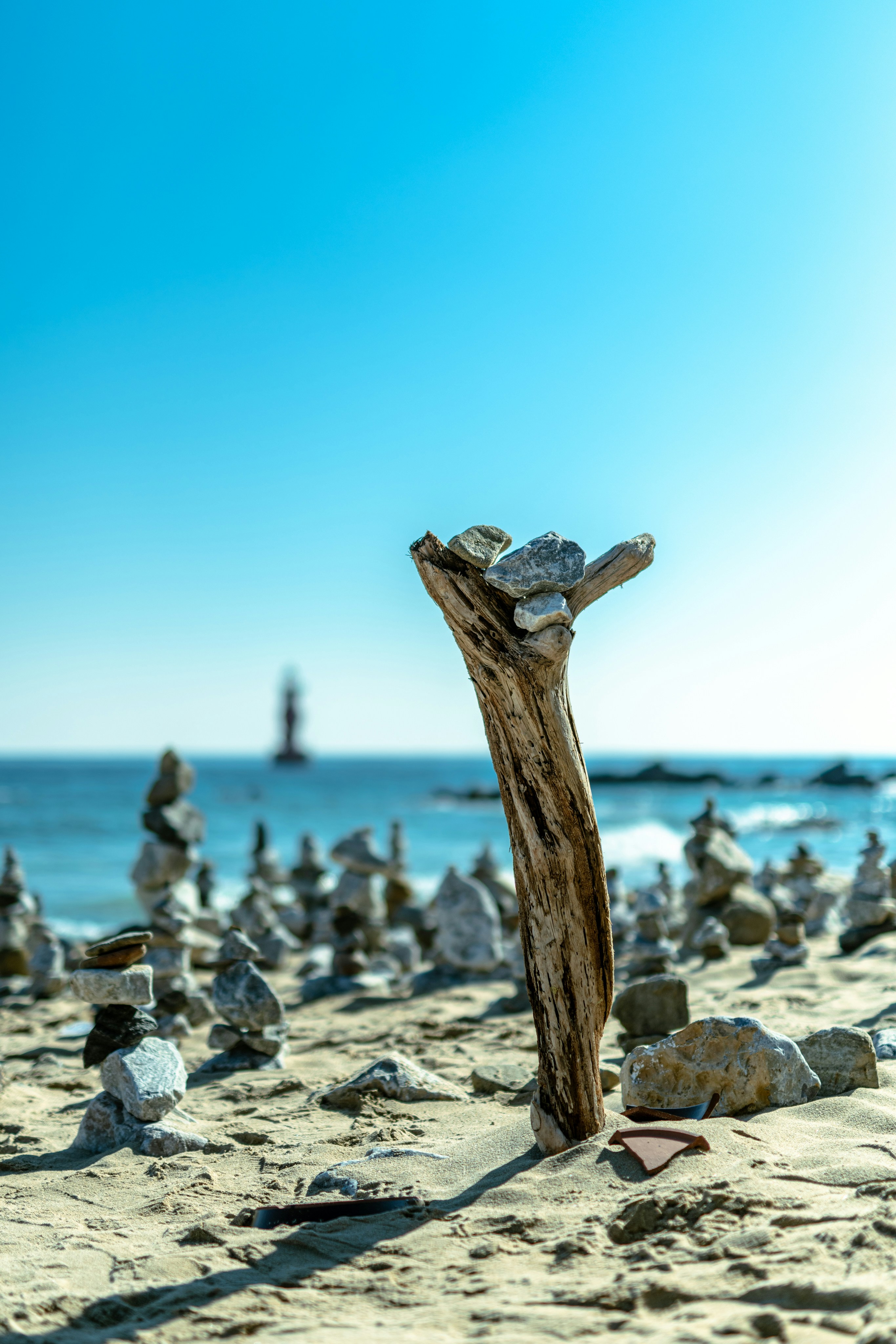 Stone Sentinel: A Sea-Worn Driftwood Rising Against a Bluer Sky