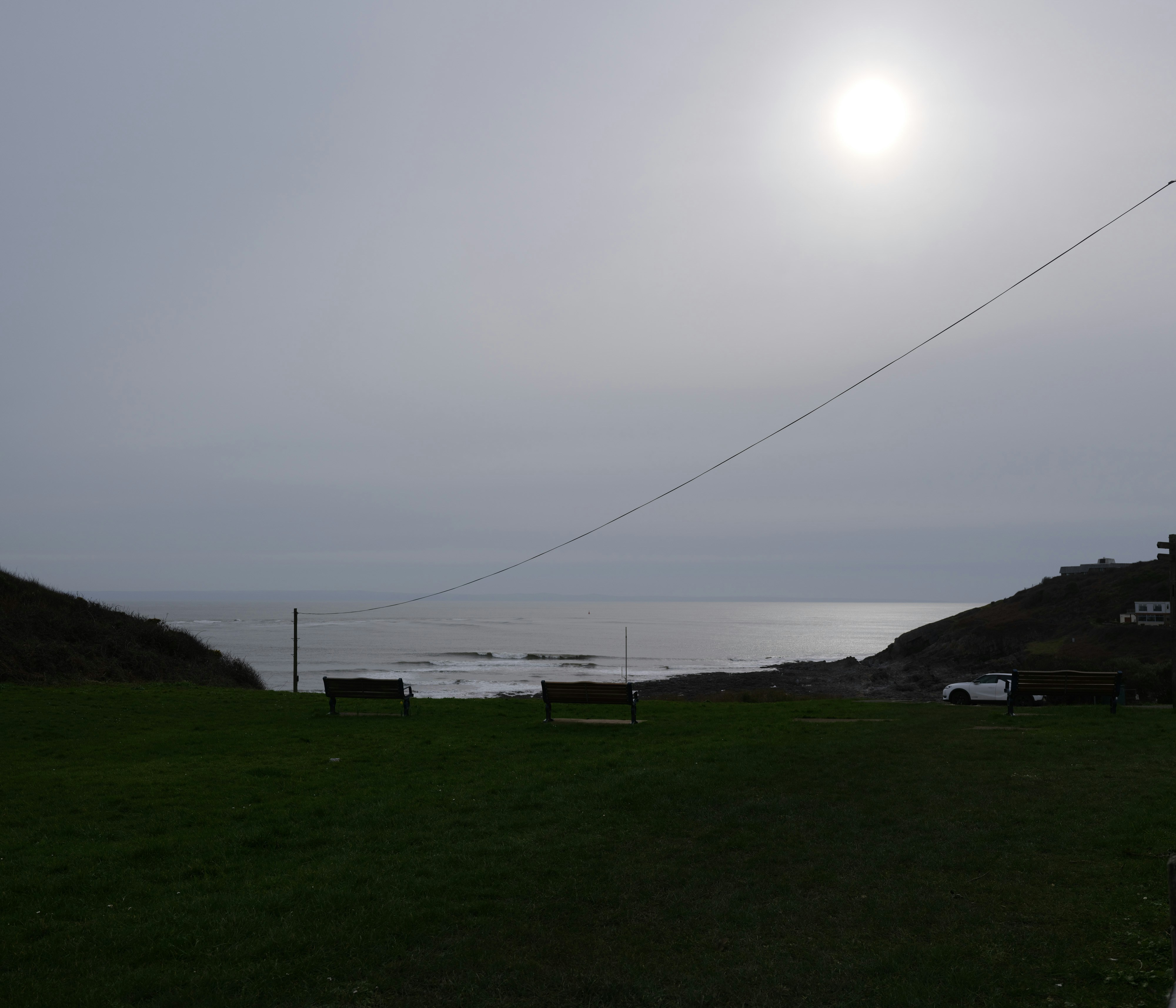 Muted Coastal Vista with Seaside Bench and Cable Highlight