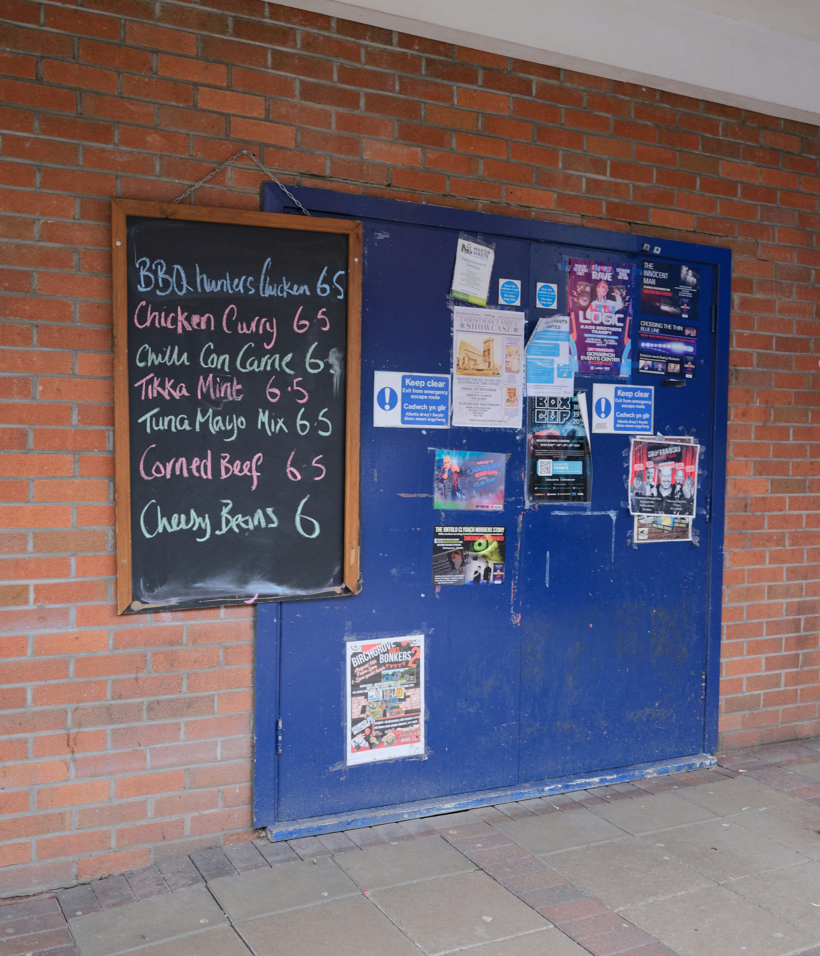 Blue Doorway Chalkboard Menu Against Brick Wall