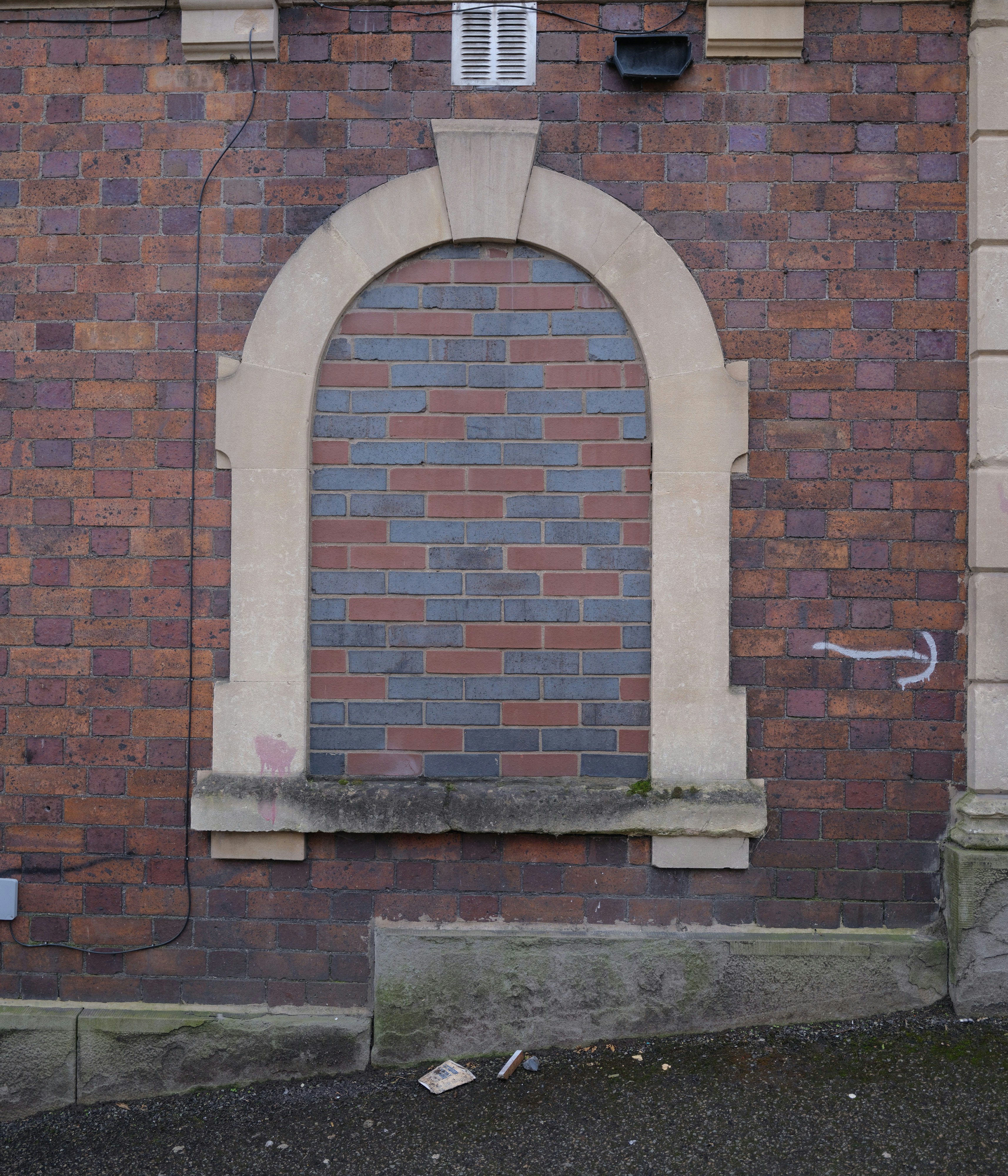 Vacant Archway on a Weathered Brick Facade