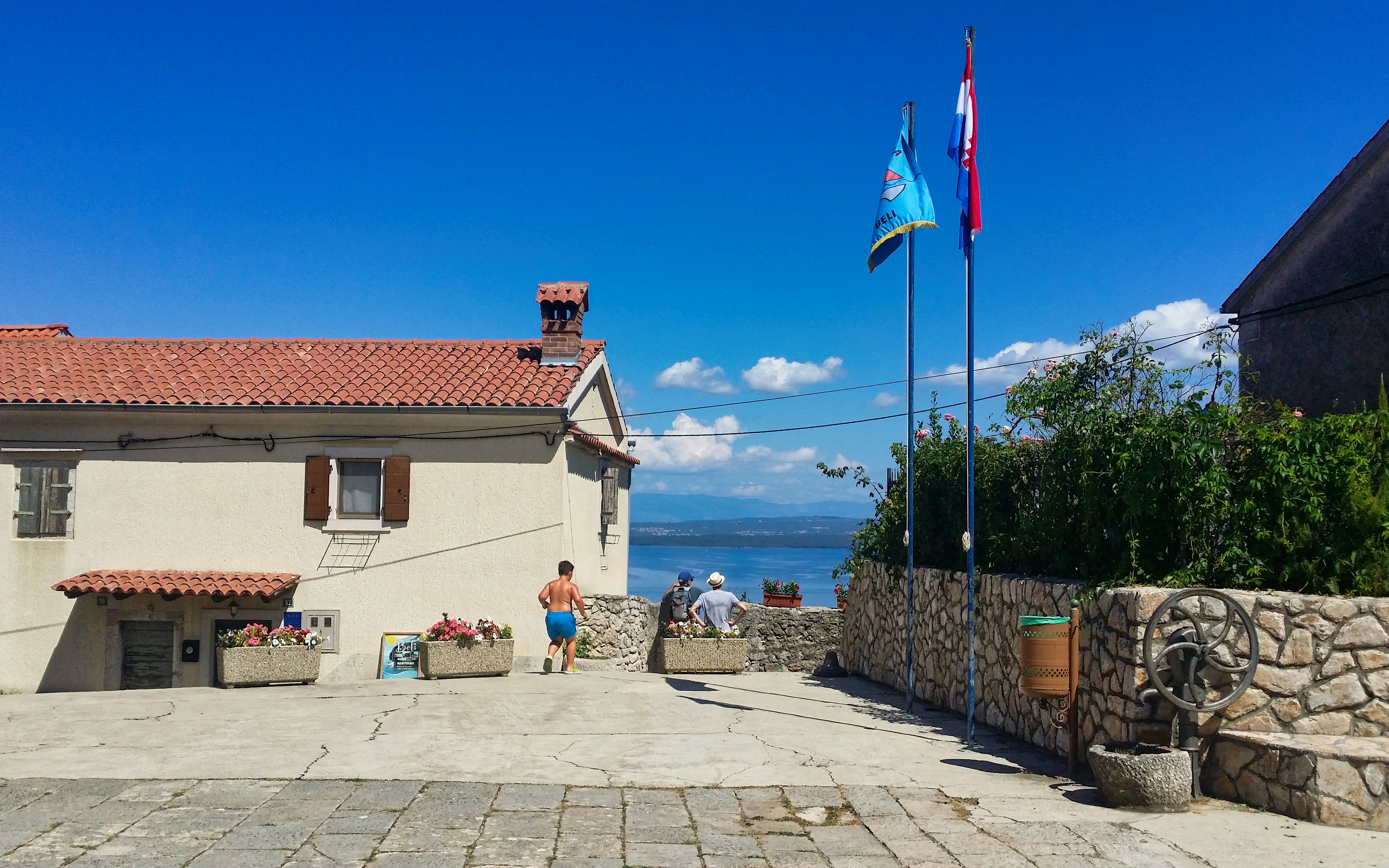 People relax by the sea on a sunny day.