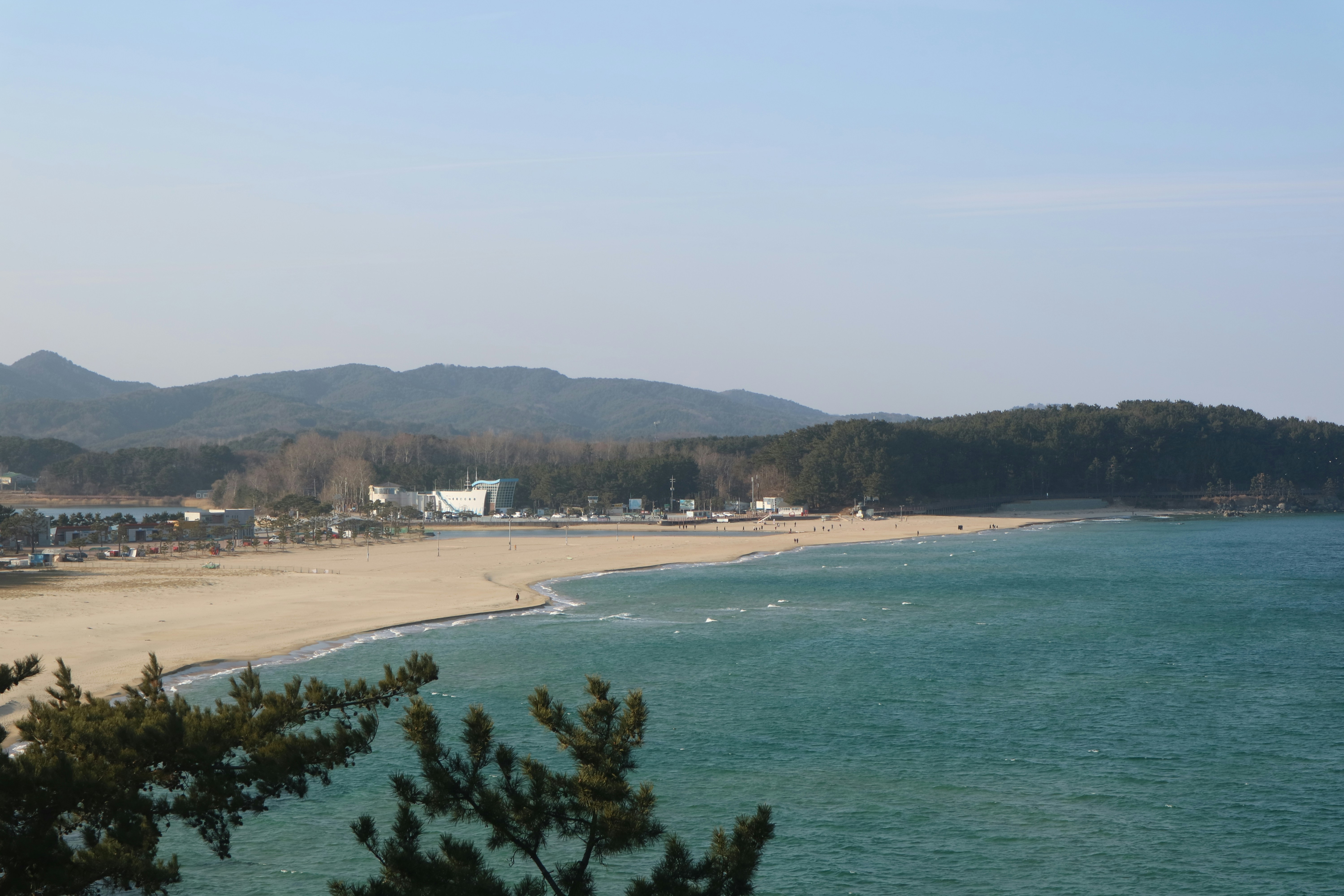 Coastal Terrace: A Quiet Beach Receding into Distant Hills