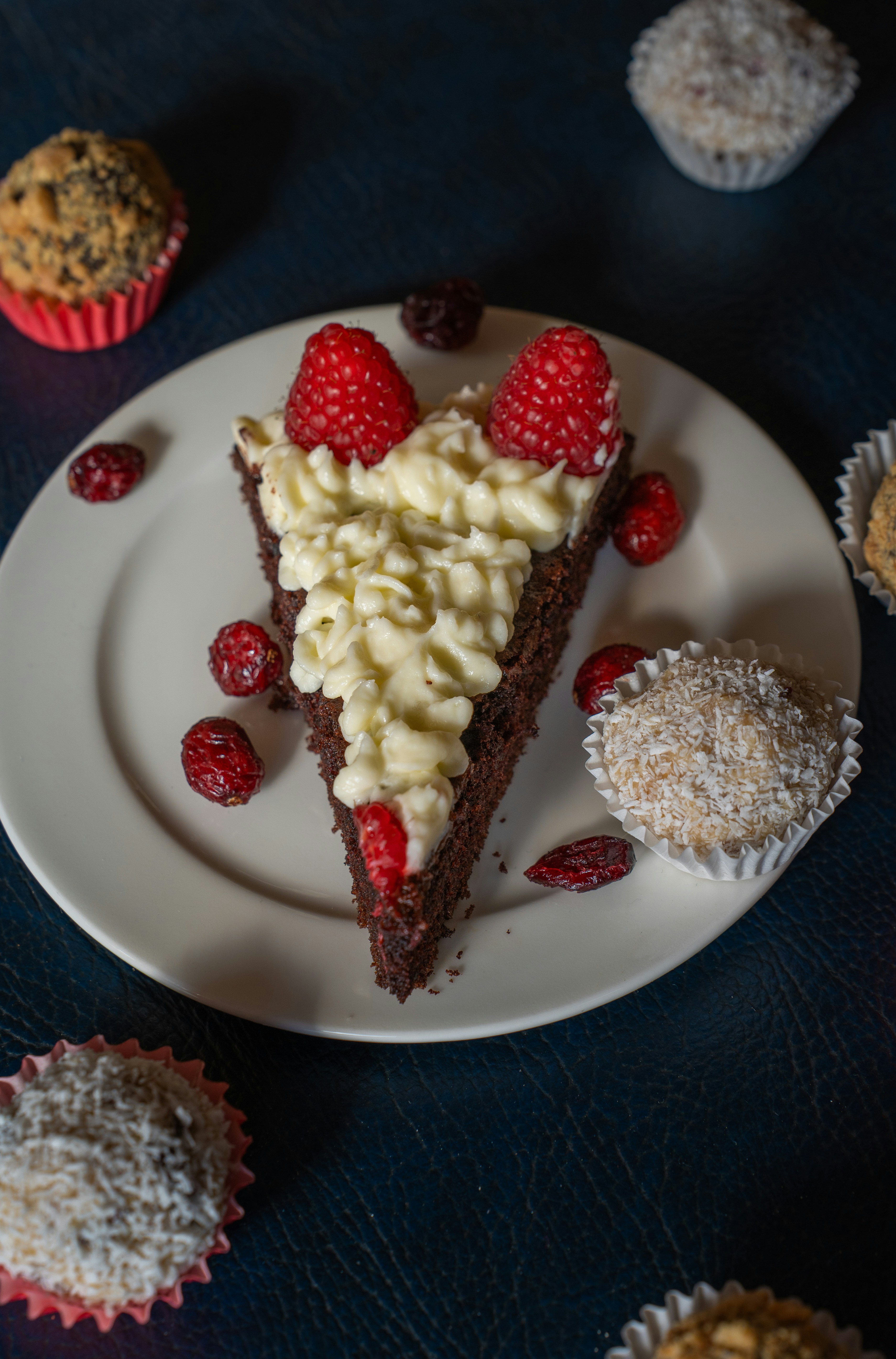 Cream-Topped Chocolate Slice Framed by Raspberry Accents