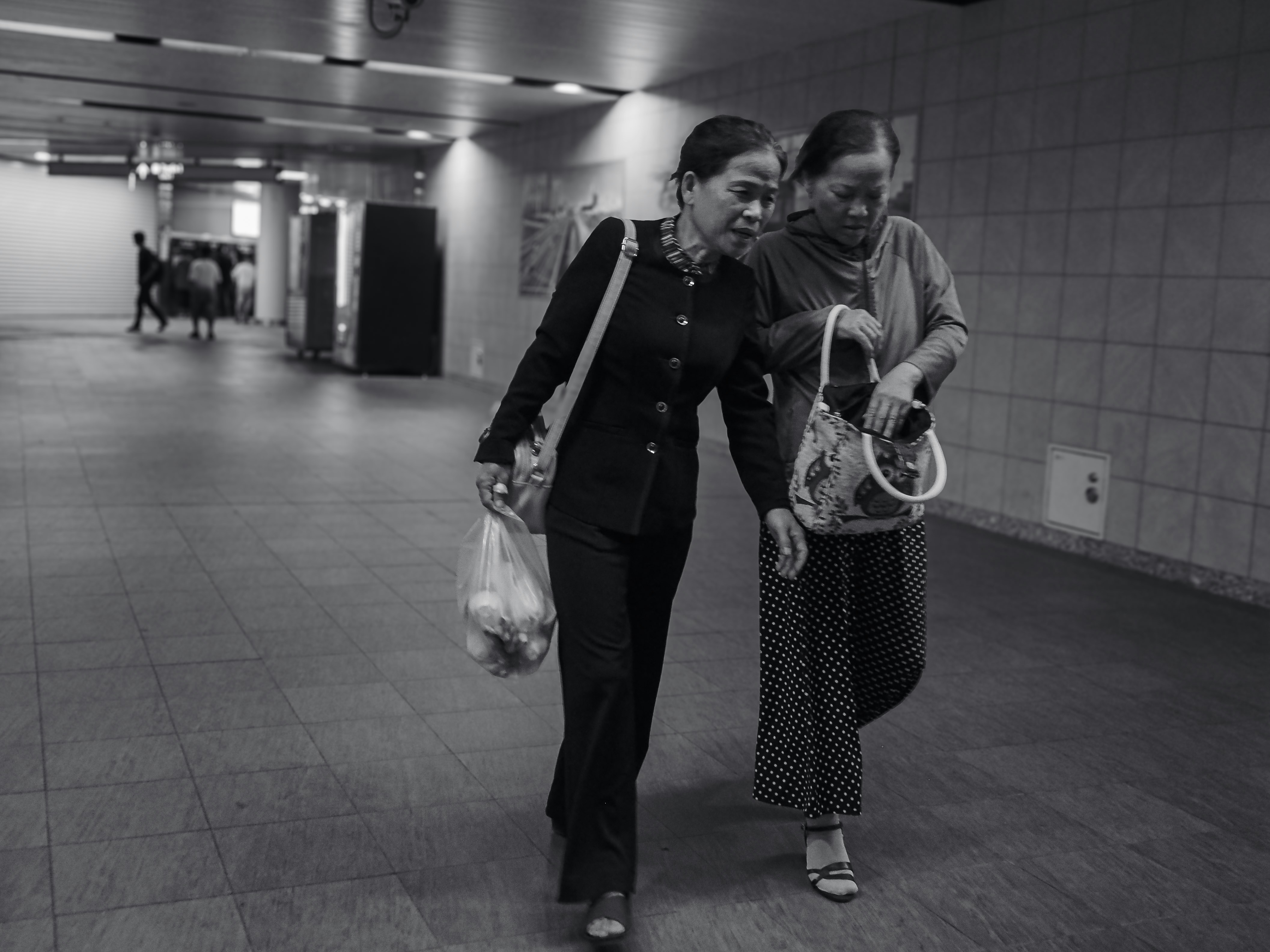 Two Women in an Underground Corridor Share a Moment