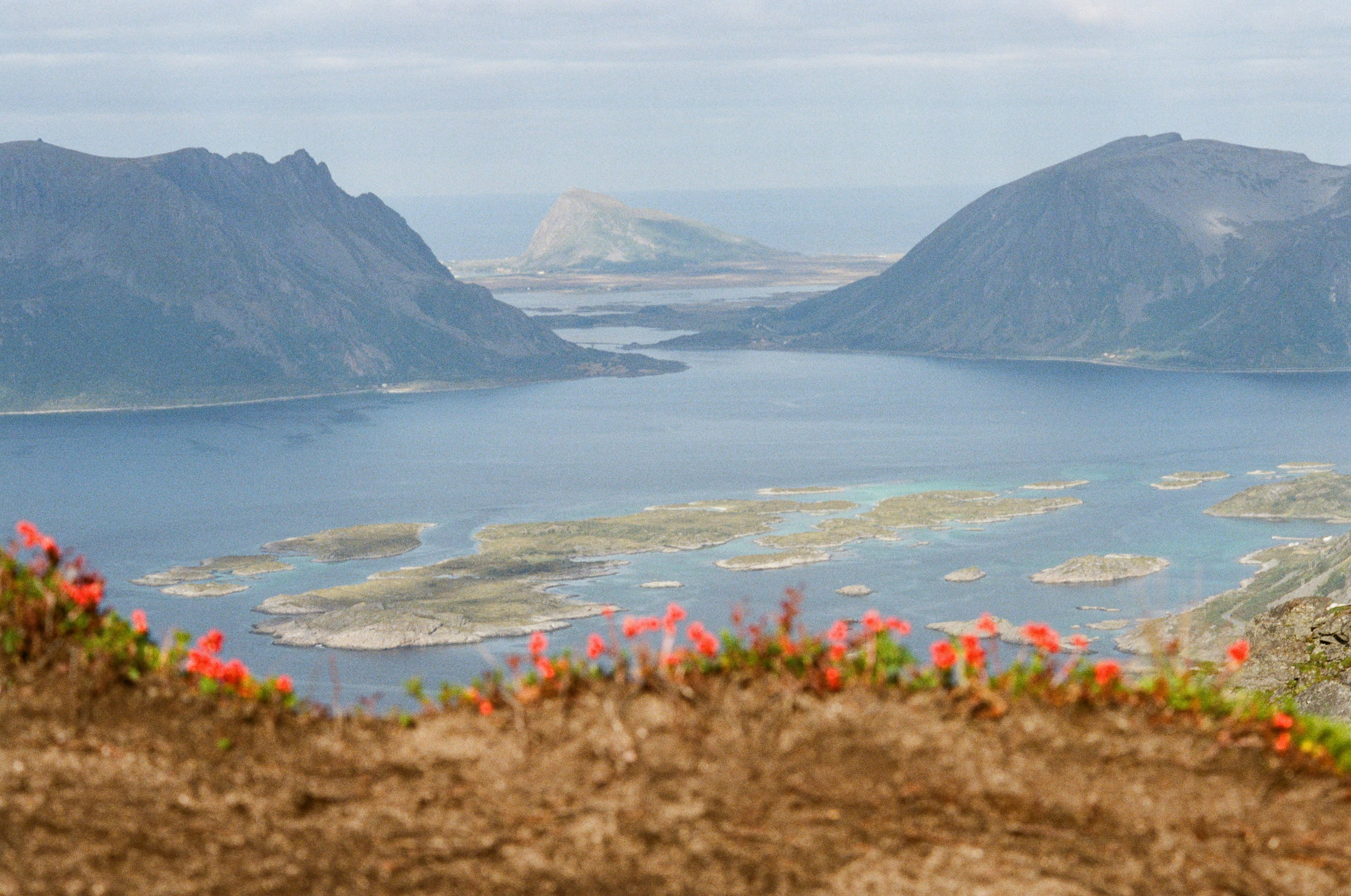 Azure Fjord Mirage: Coastal Inlet Between Rugged Peaks