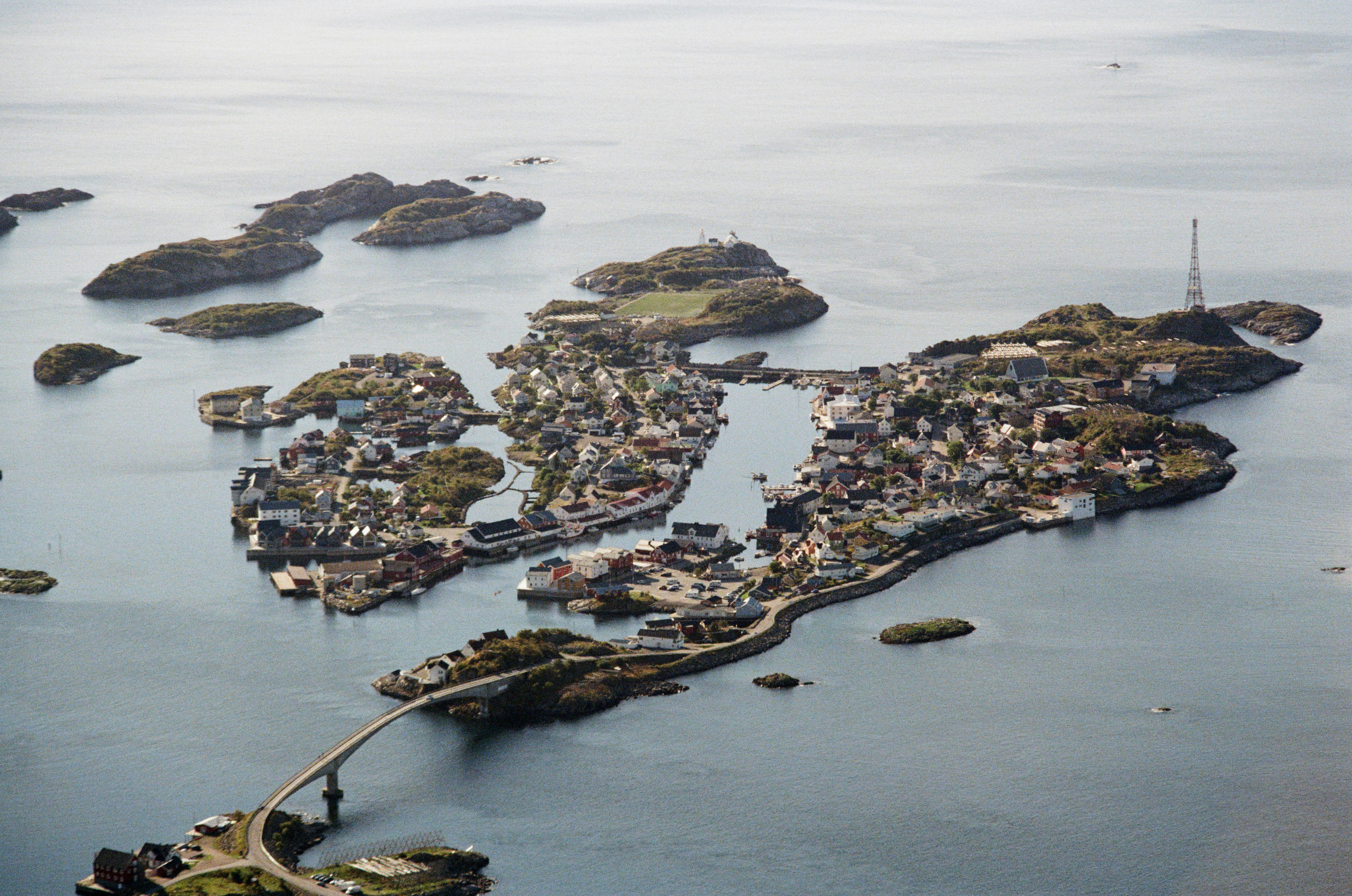 Archipelago with bridge connecting small islands and coastal town.