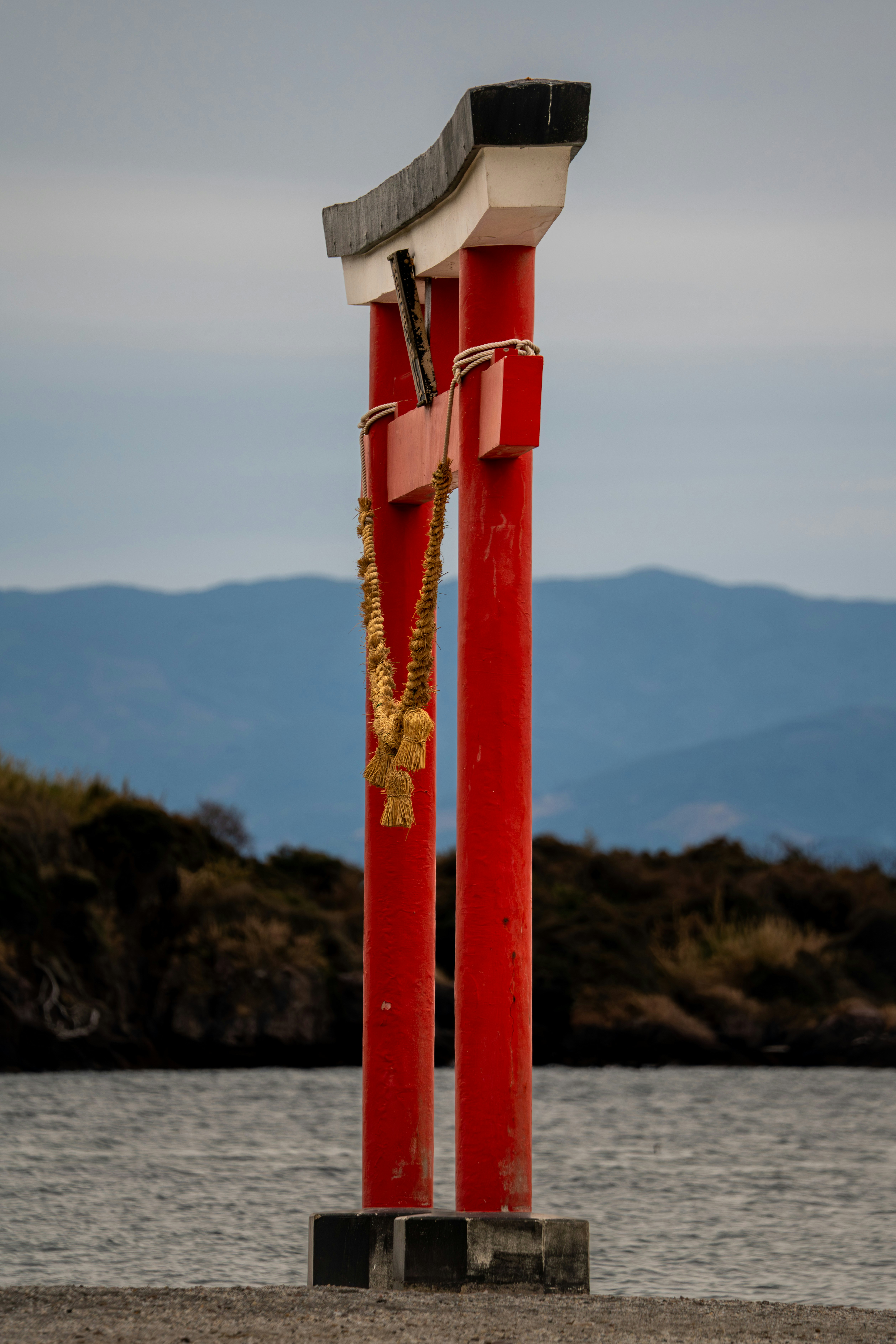 Red Torii Rising from Quiet Water Under a Distant Ridge