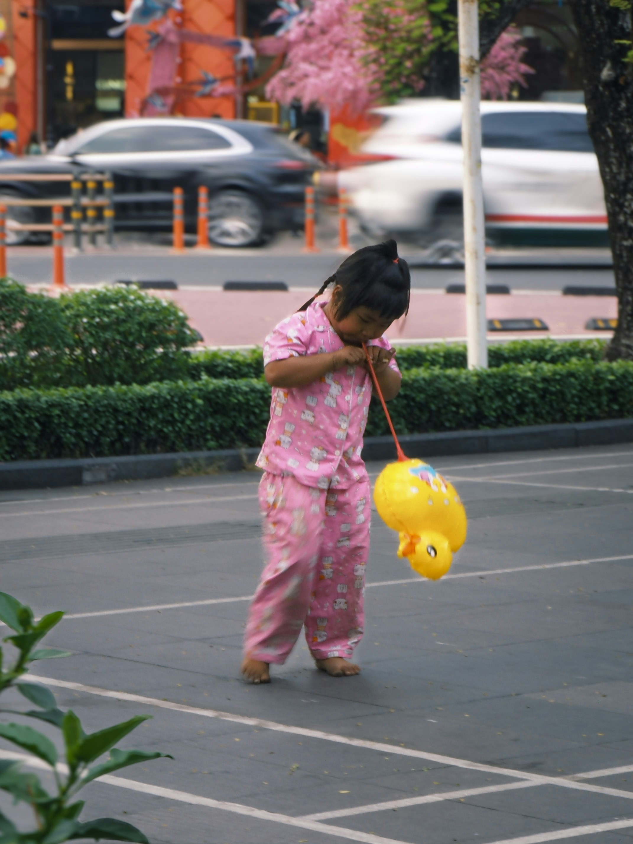 Small Pink Pajamas, Big Yellow Lantern: A Quiet Moment on the City Street