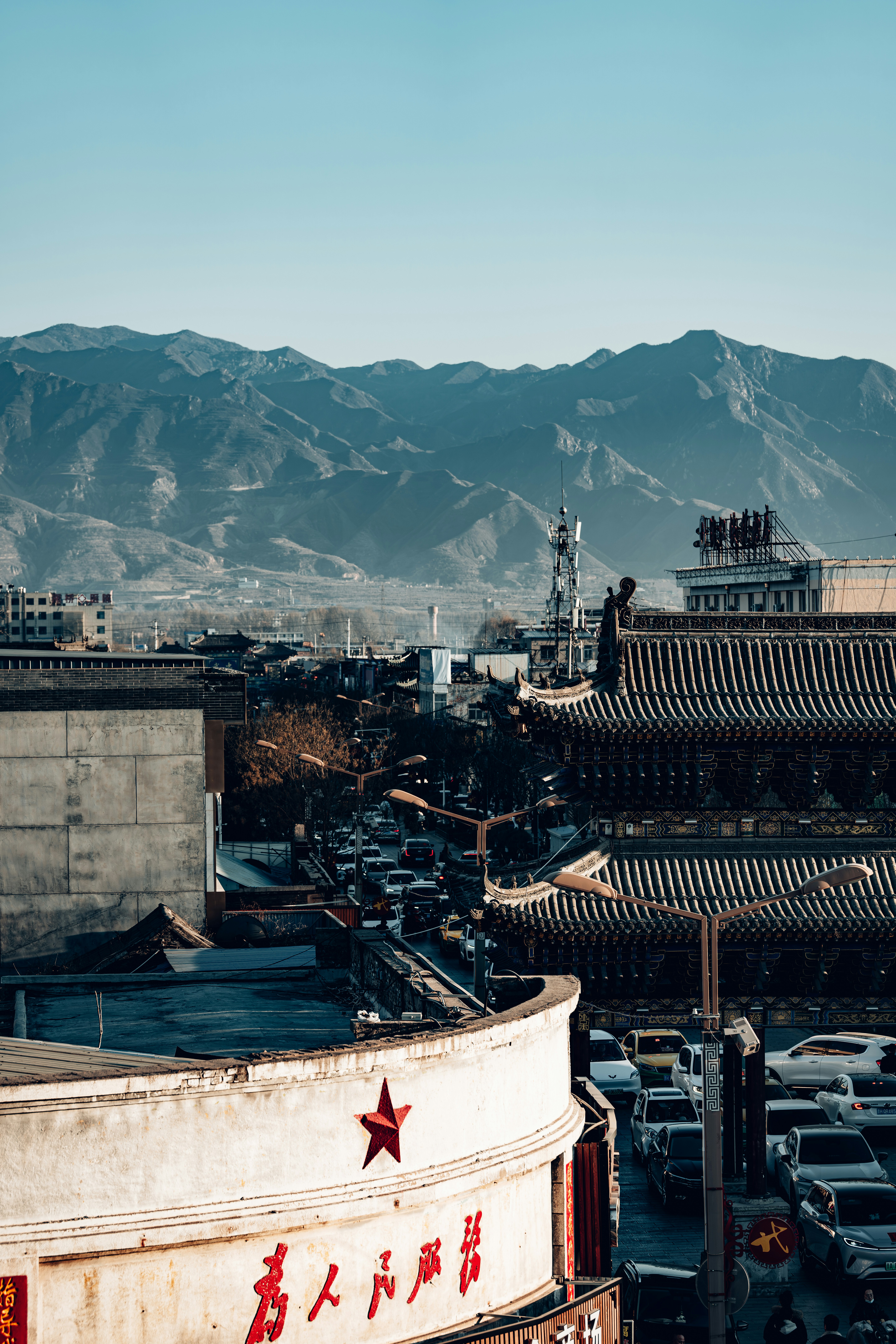 City Gate and Mountain Horizon: A Tapestry of Roof Tiles and Traffic