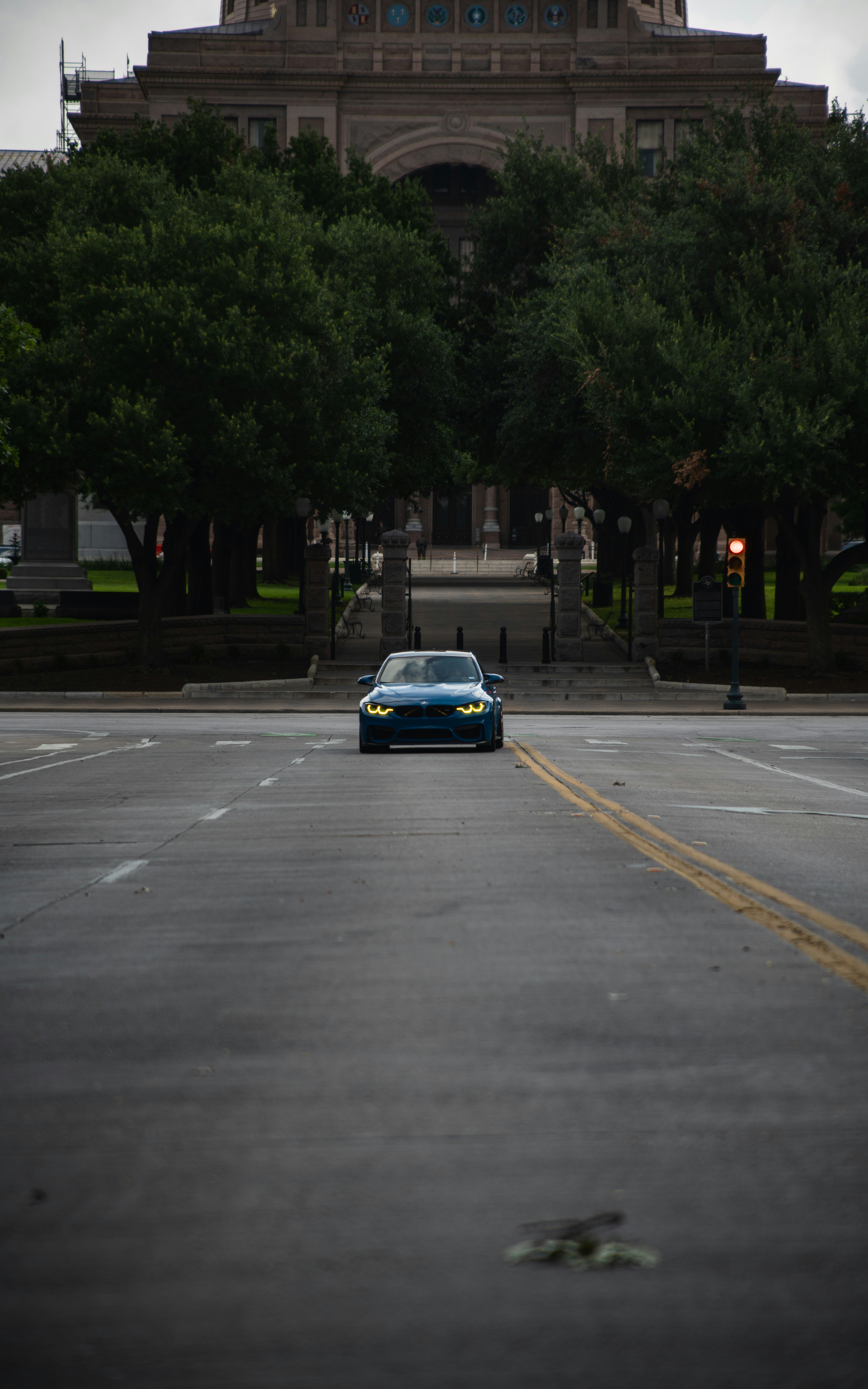 Blue Car at the Gate: A City Street Leads to a Historic Facade