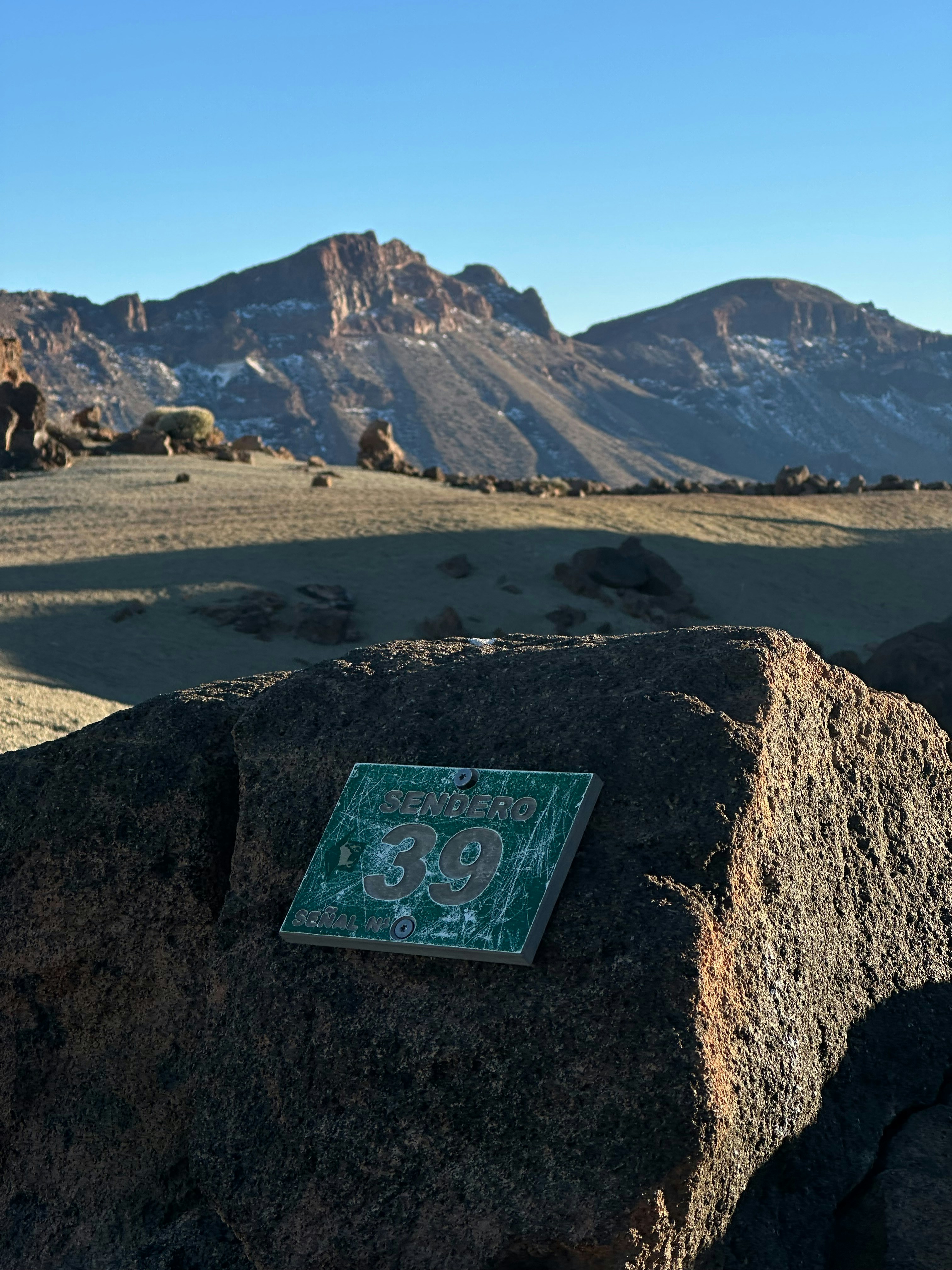 Rocky Desert Signpost Beneath Distant Mountain Ridge