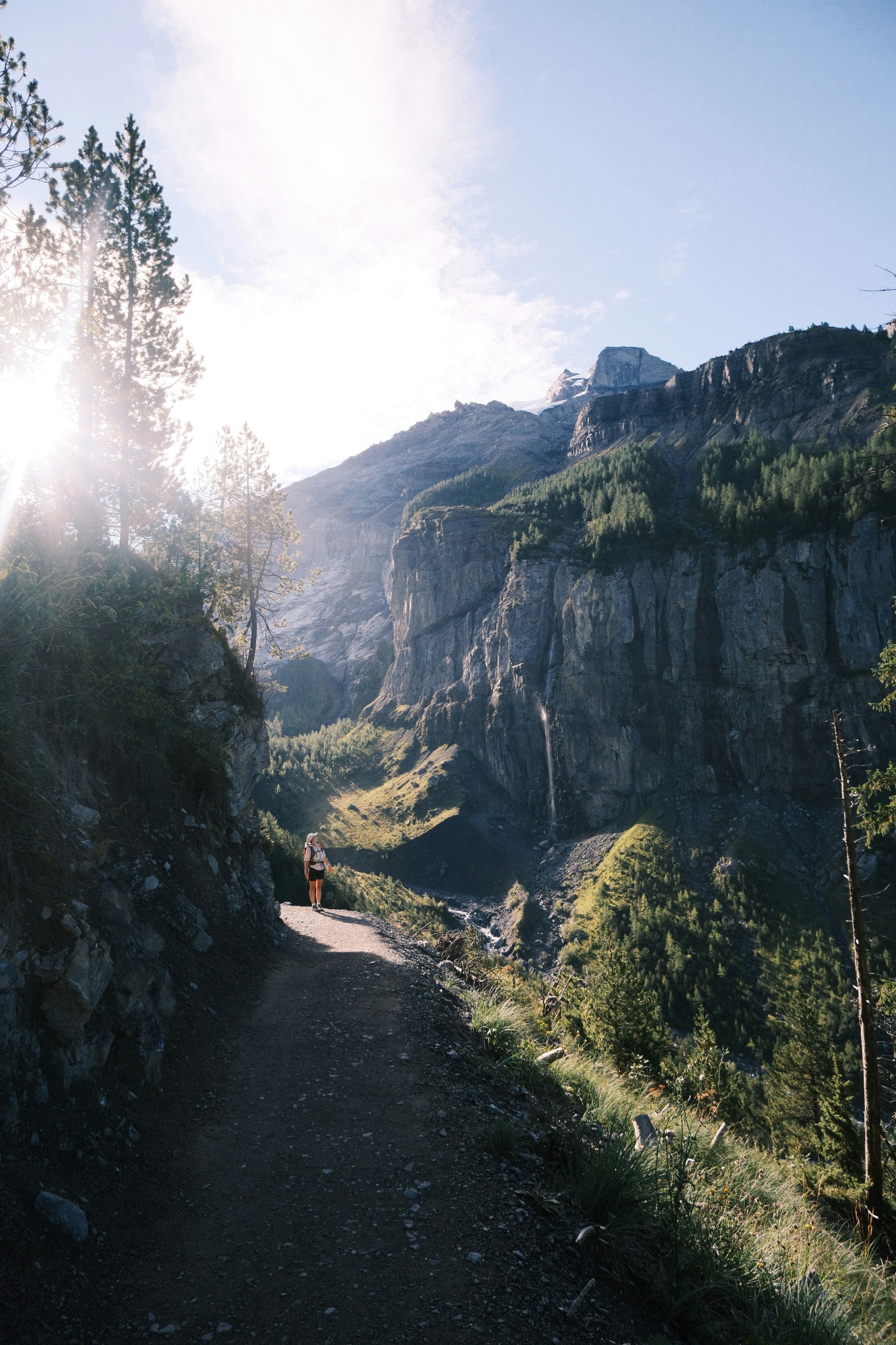Trail Between Giants: A Sunlit Path Through Alpine Cliffs