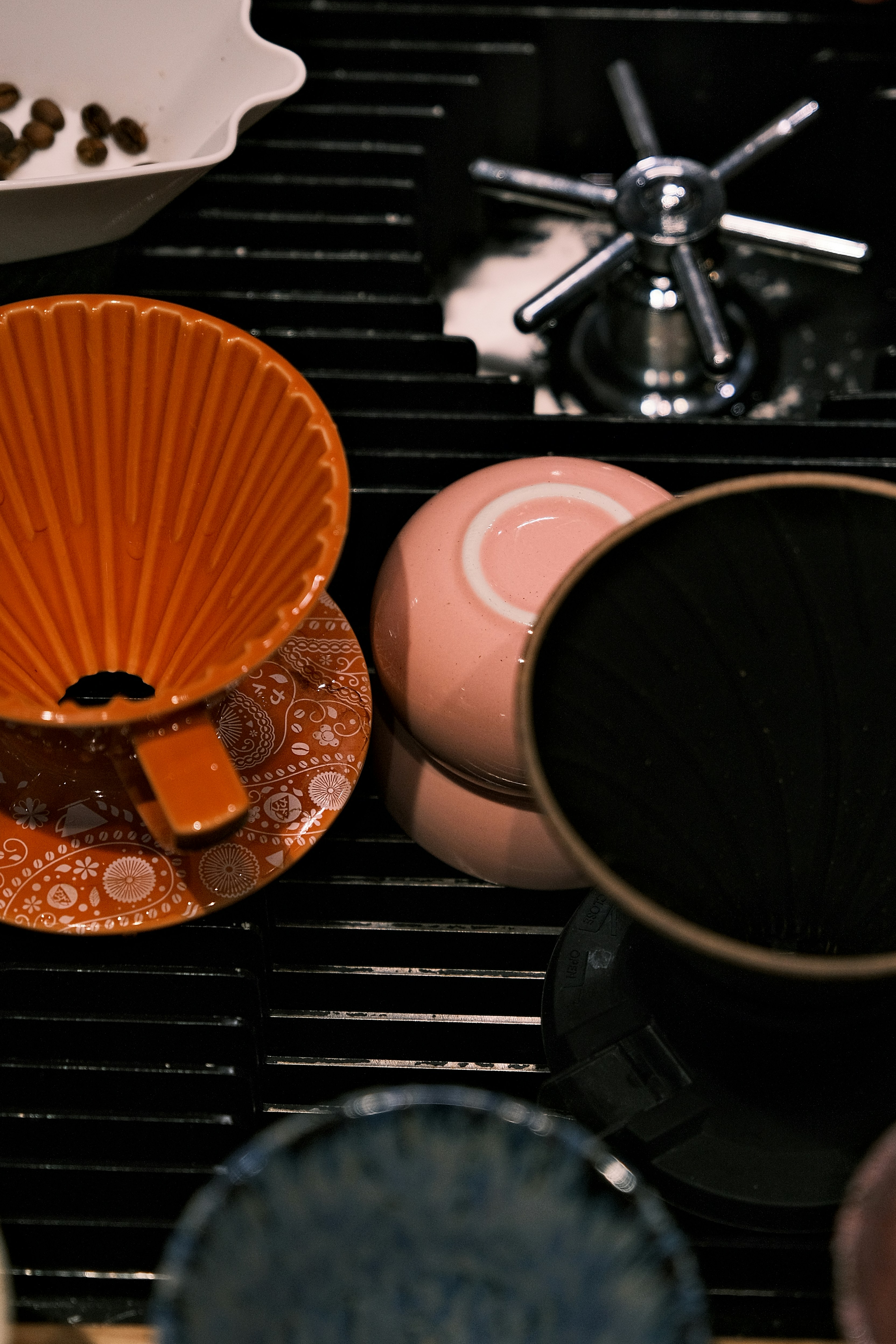 Ceramic Cups and Saucer Nestled on a Glossy Stovetop Grid