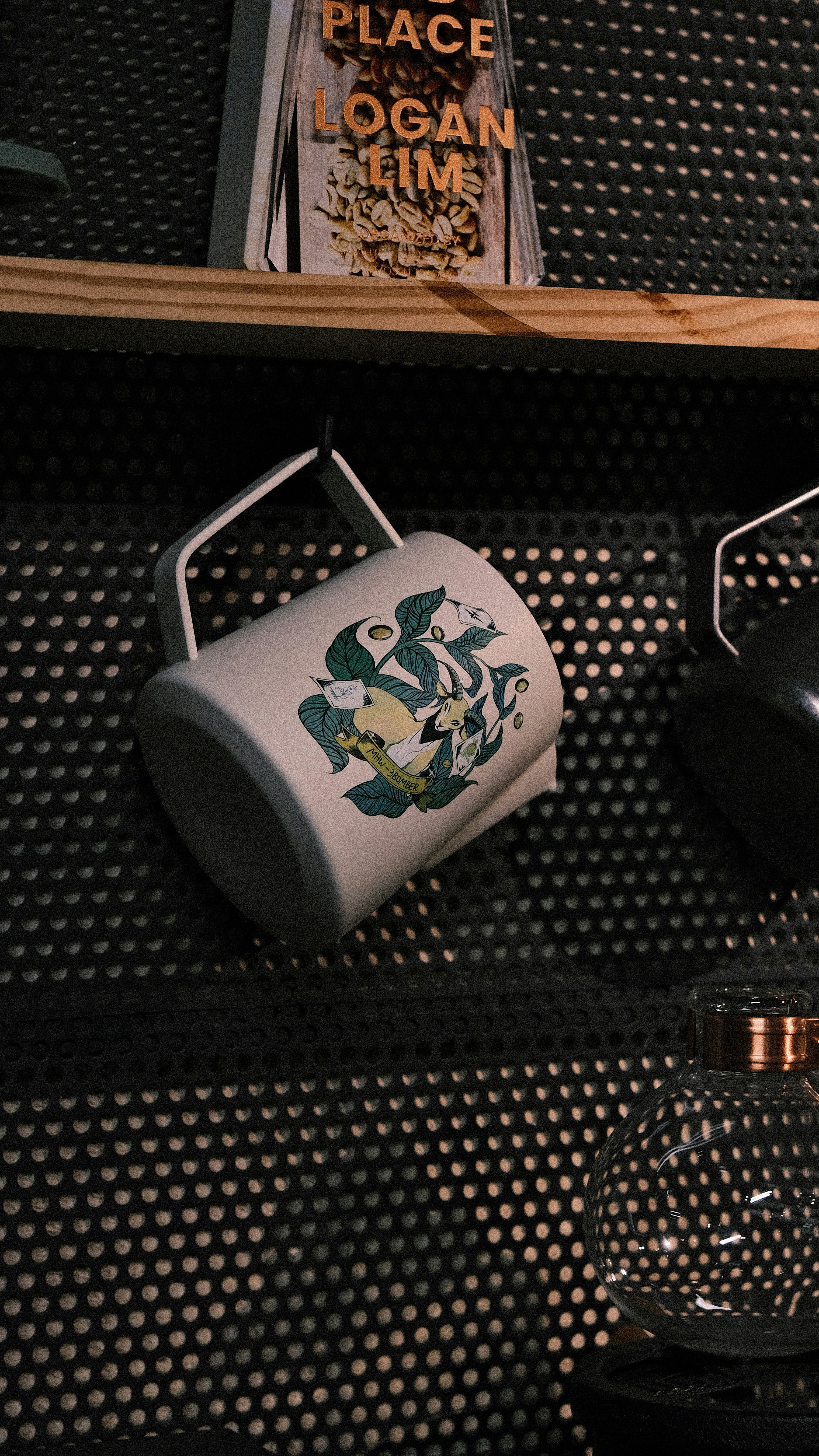 Mug on a perforated shelf: botanical graphics and warm light