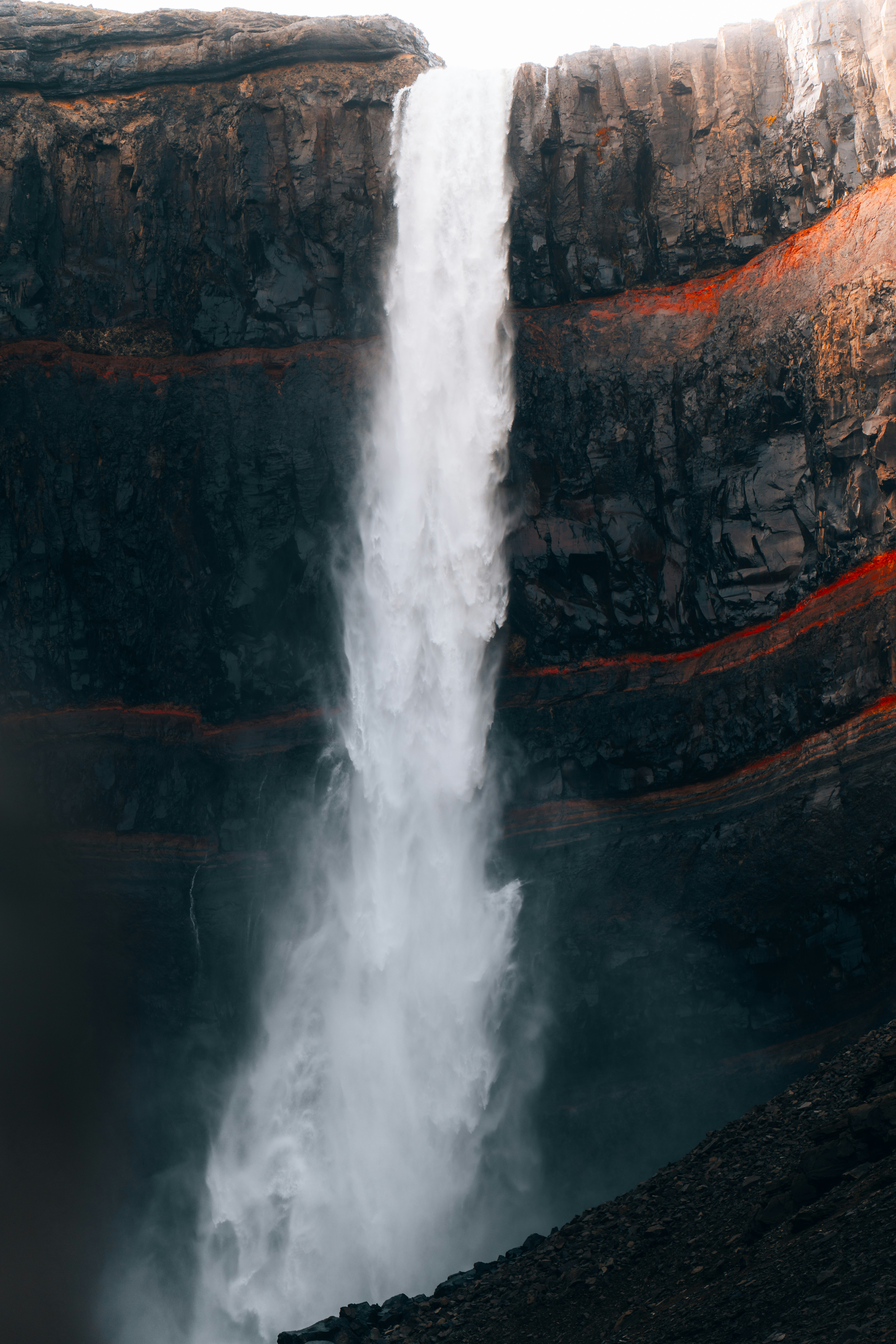 Cascading Veil: A Towering Icelandic Waterfall Between Basalt Rims