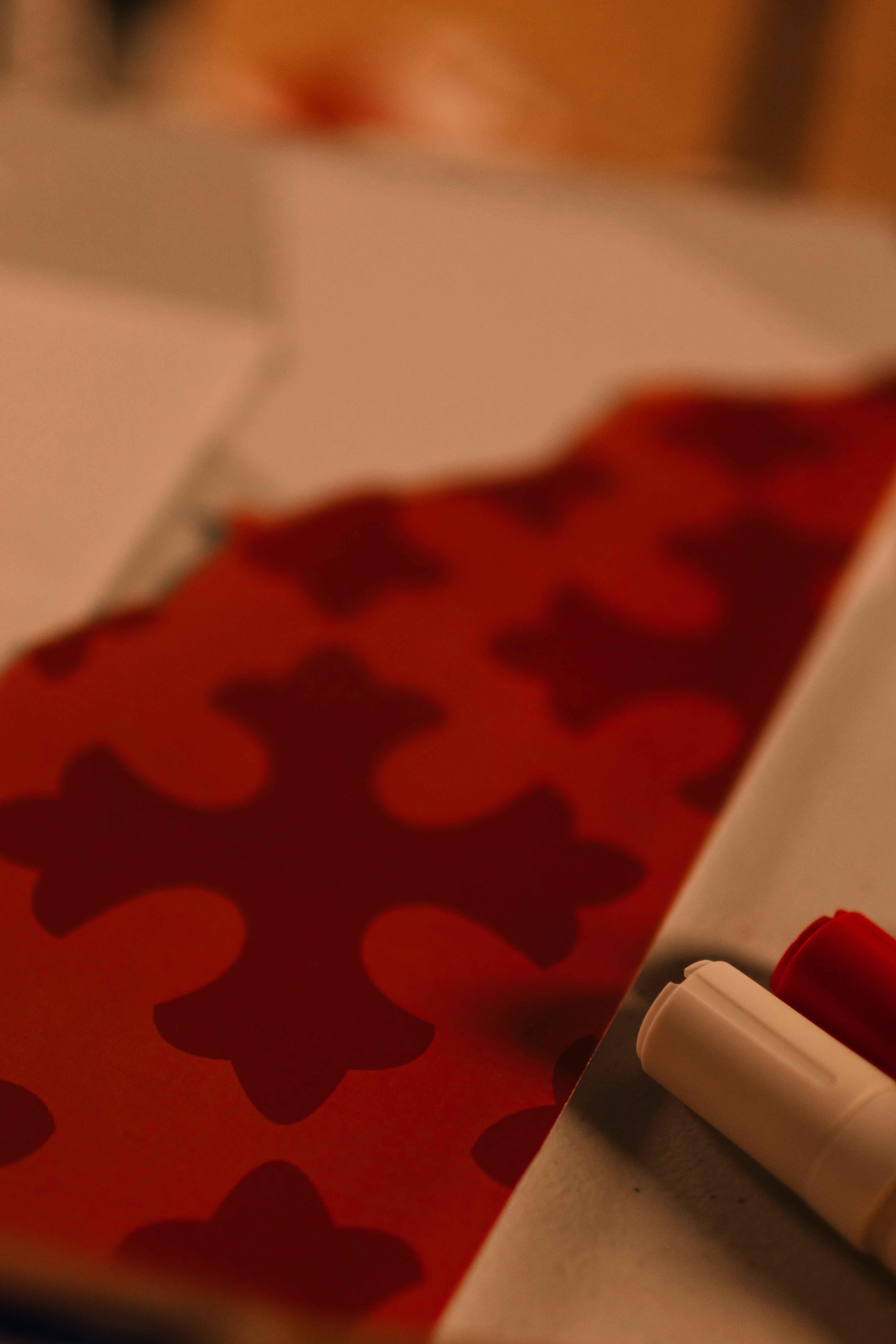 Red Ribbon Focus: A Cozy Craft Moment on a Paper Table