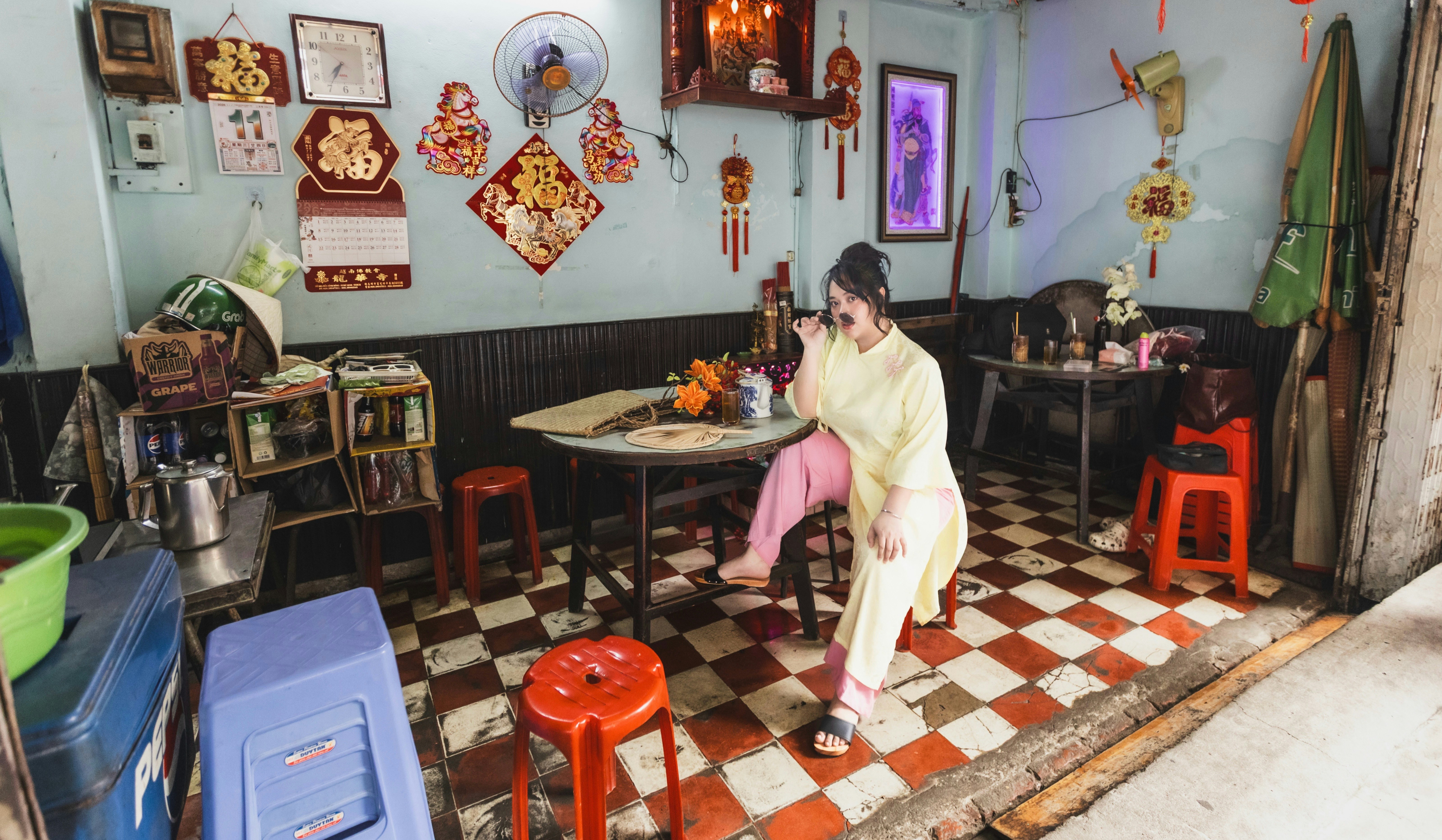 Quiet Moment in a Small Eatery: A Woman in Yellow and Pink Lounges with Tea