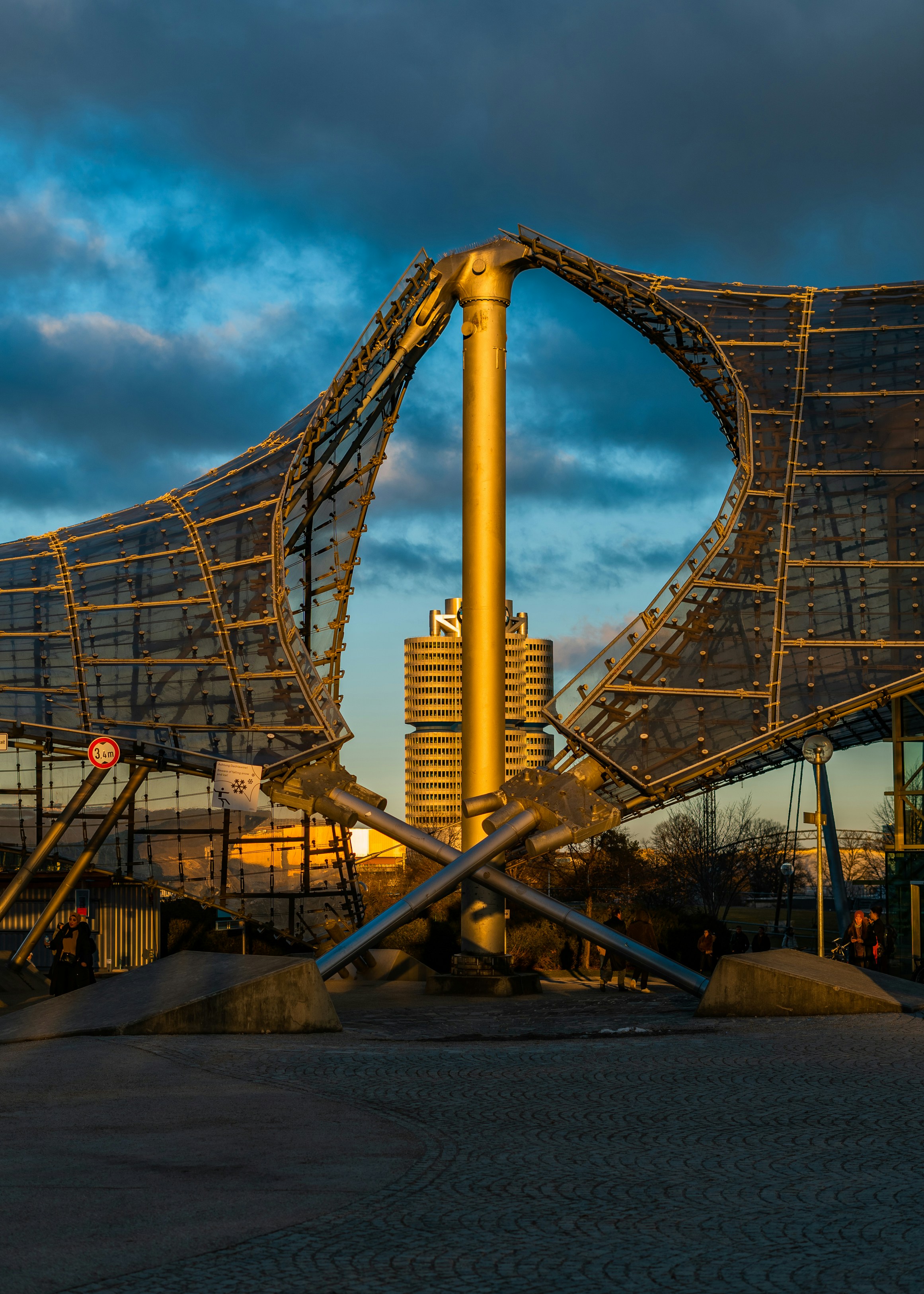 Golden Central Pillar Framed by Arched Steel Canopy at Dusk